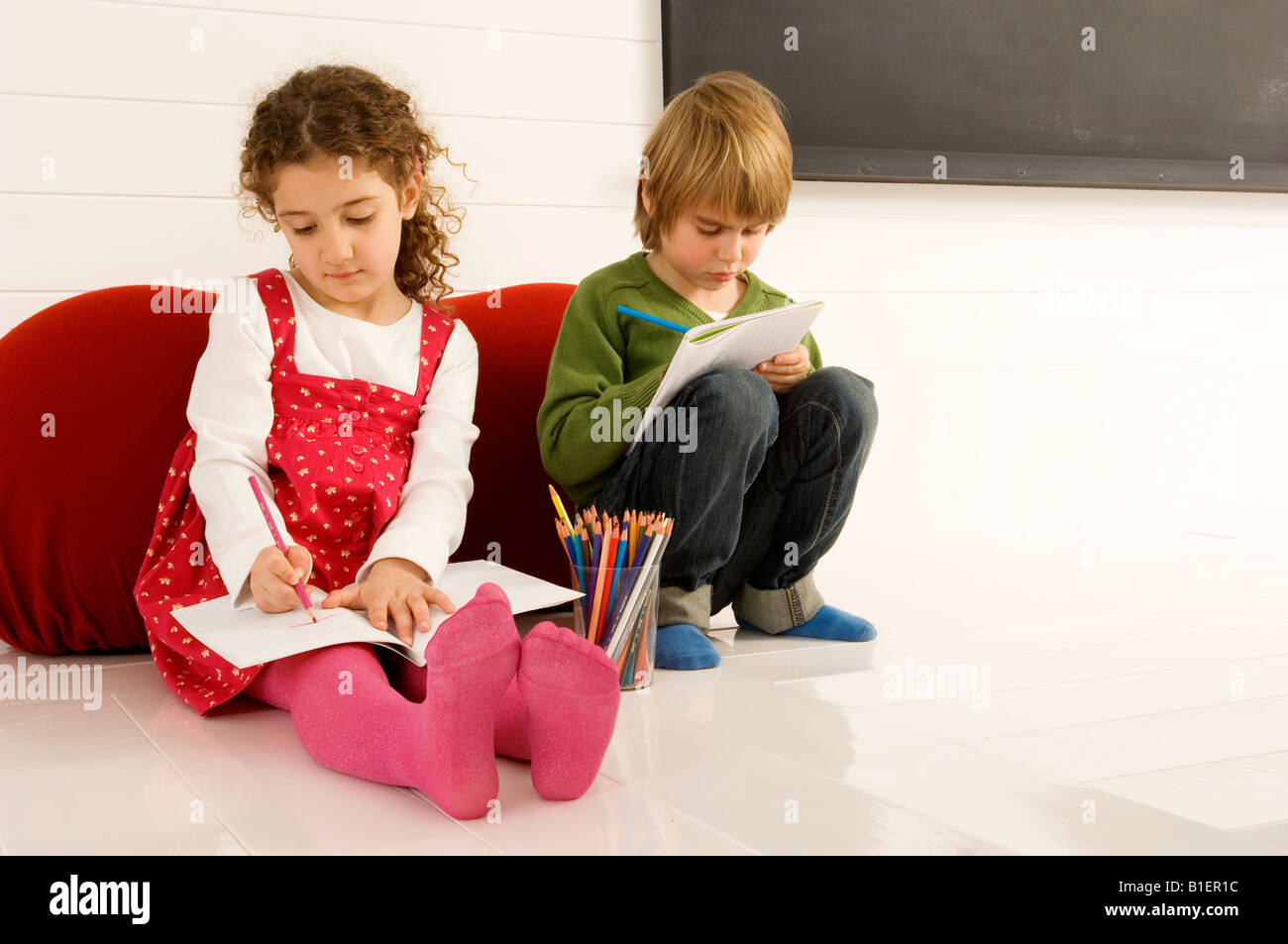 Boy and a girl drawing on notepads Stock Photo - Alamy