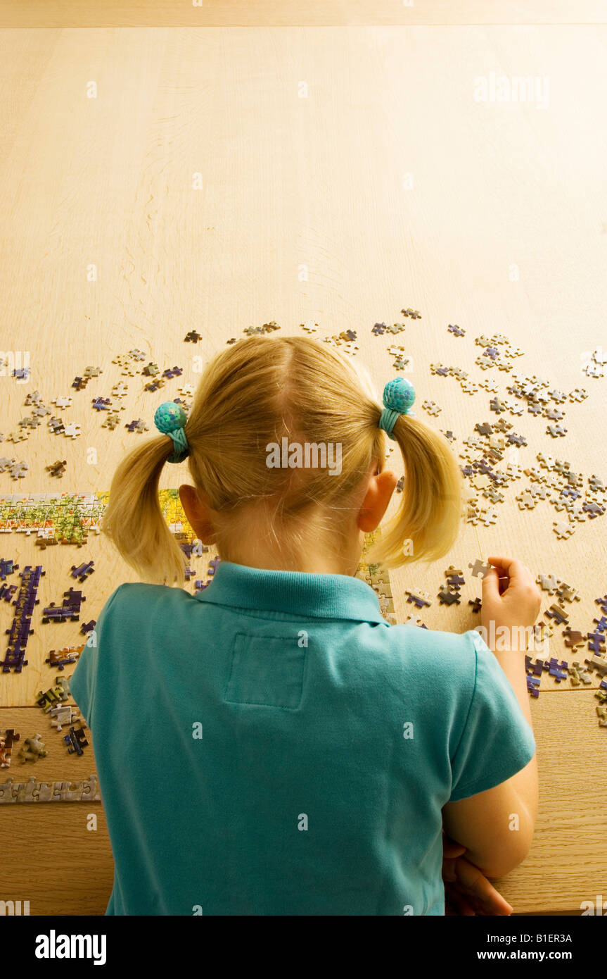 Rear view of a girl playing a jigsaw puzzle Stock Photo - Alamy