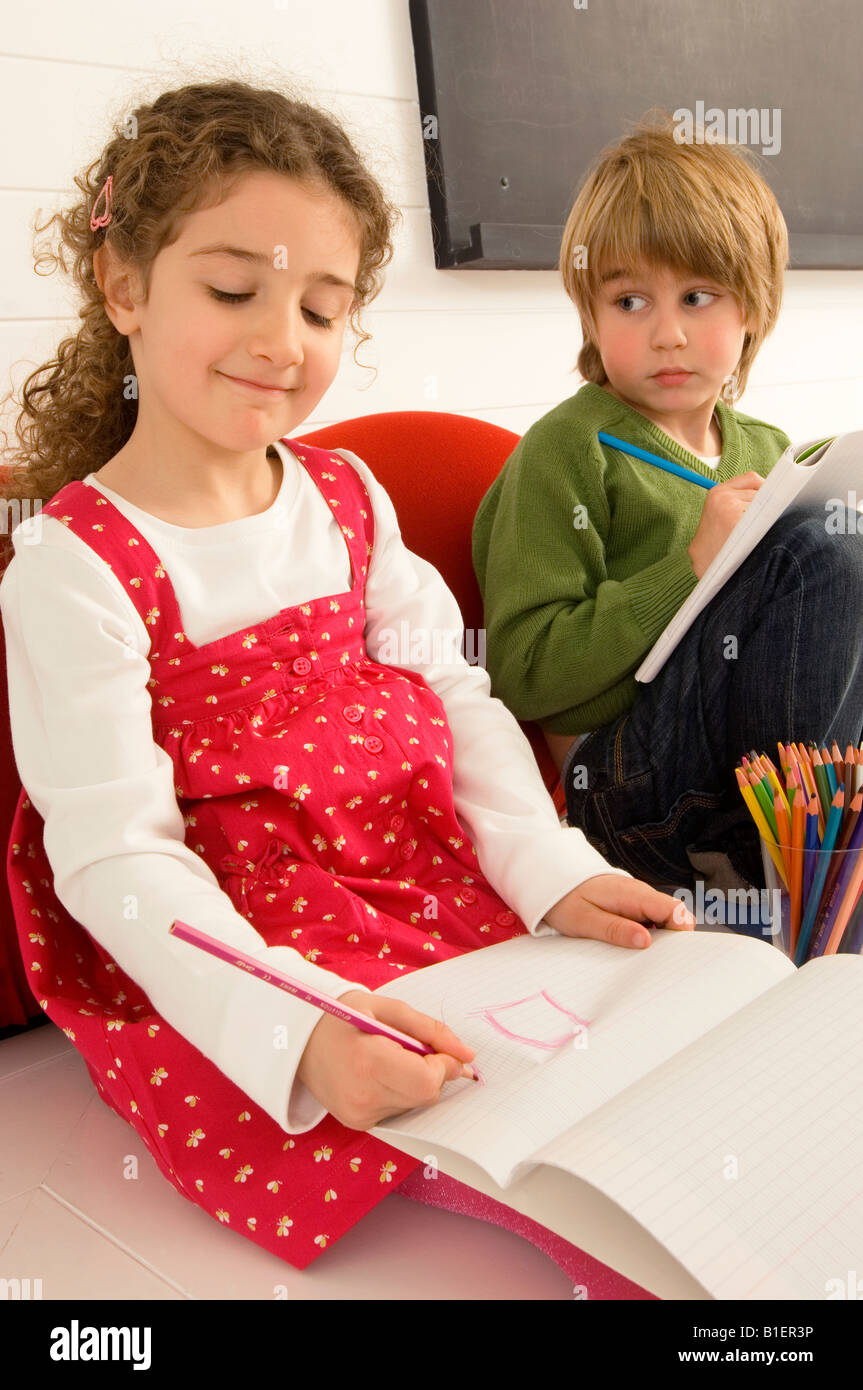 Girl drawing on a notepad and her brother looking at her Stock Photo ...