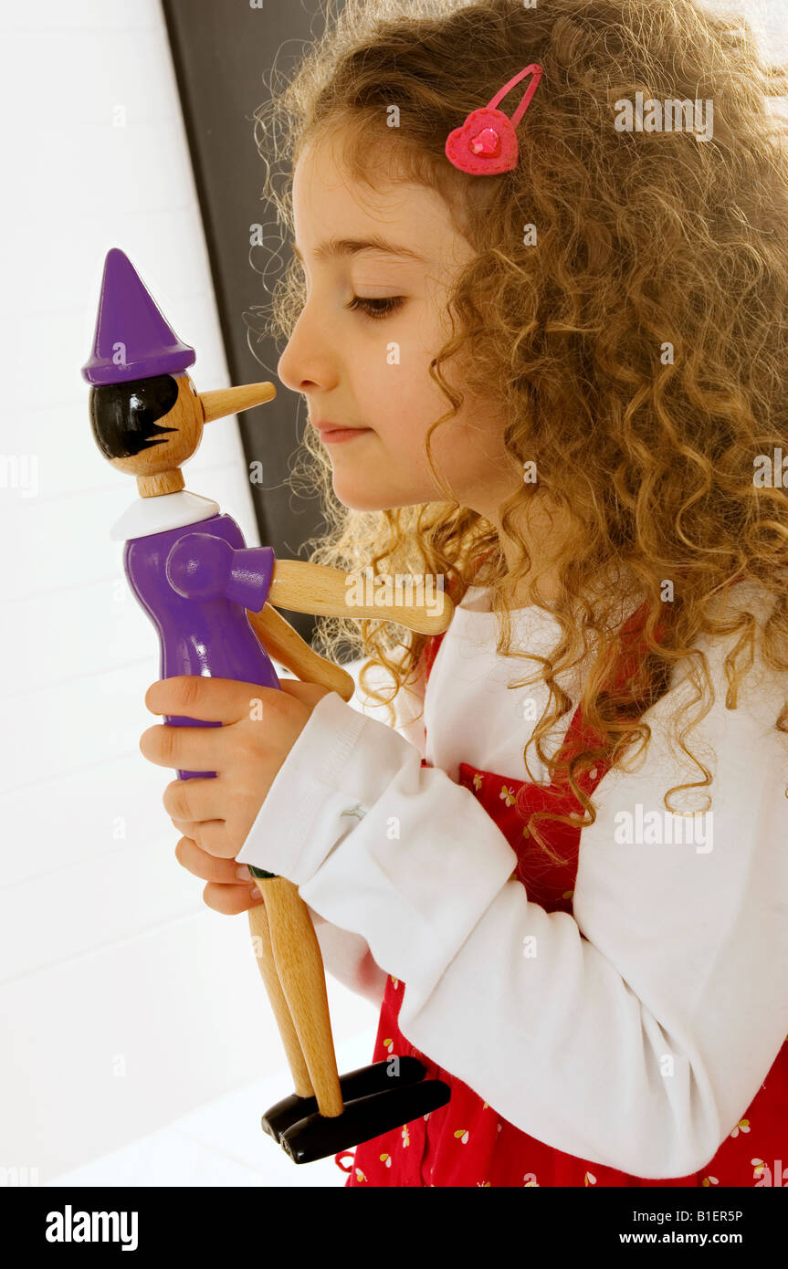 Side profile of a girl playing with a toy Stock Photo - Alamy