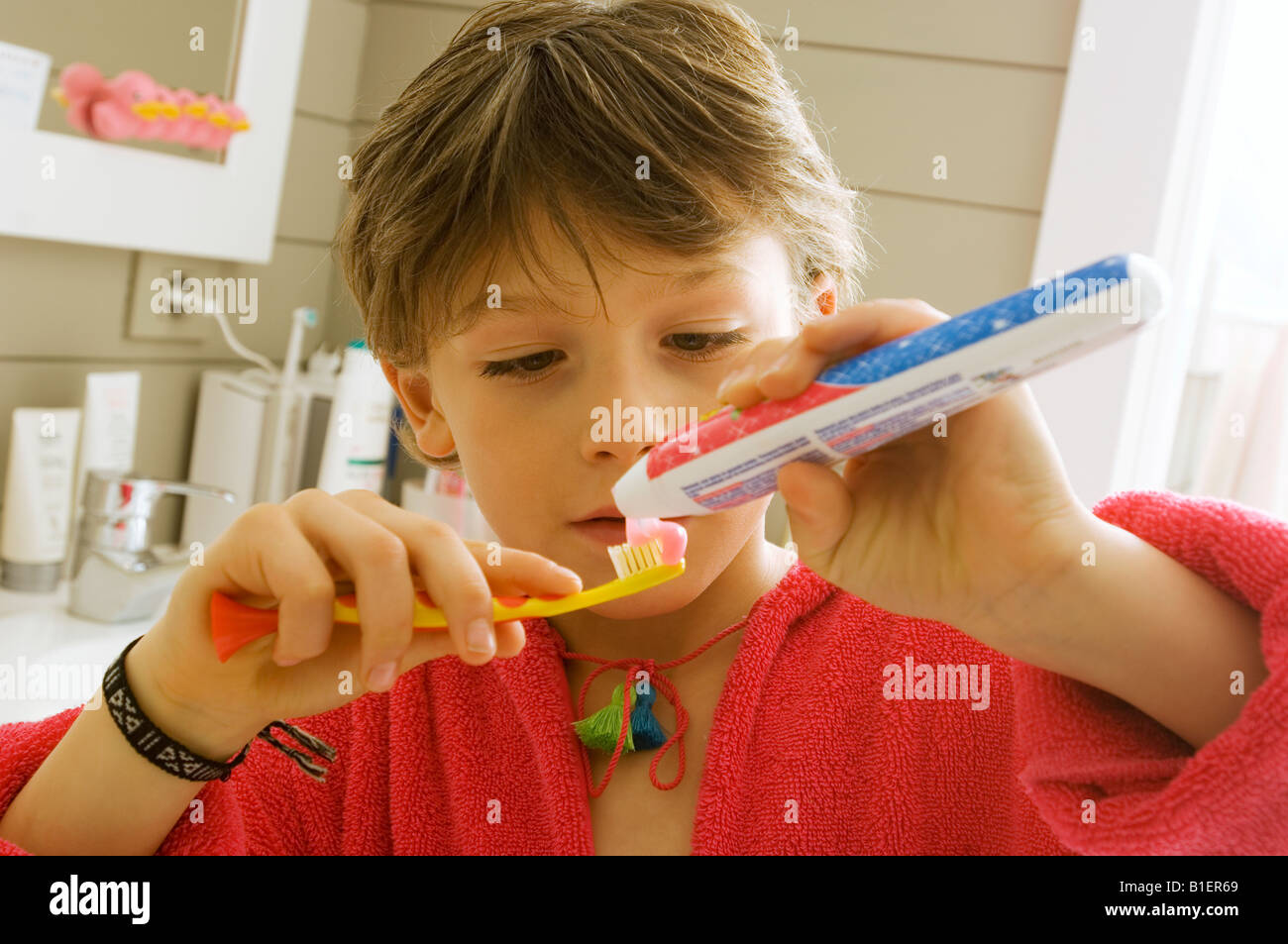 Close-up of a boy holding a toothpaste and a toothbrush Stock Photo - Alamy