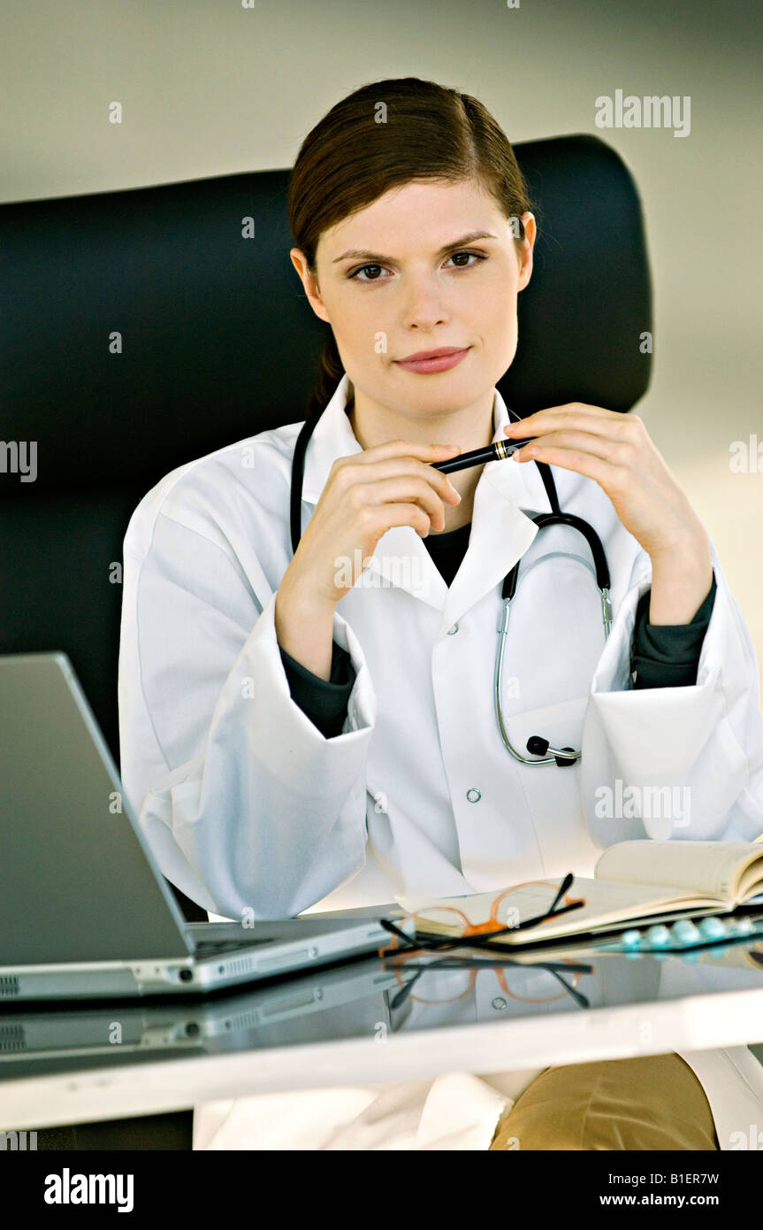 Portrait of a female doctor sitting at a desk in her office Stock Photo ...