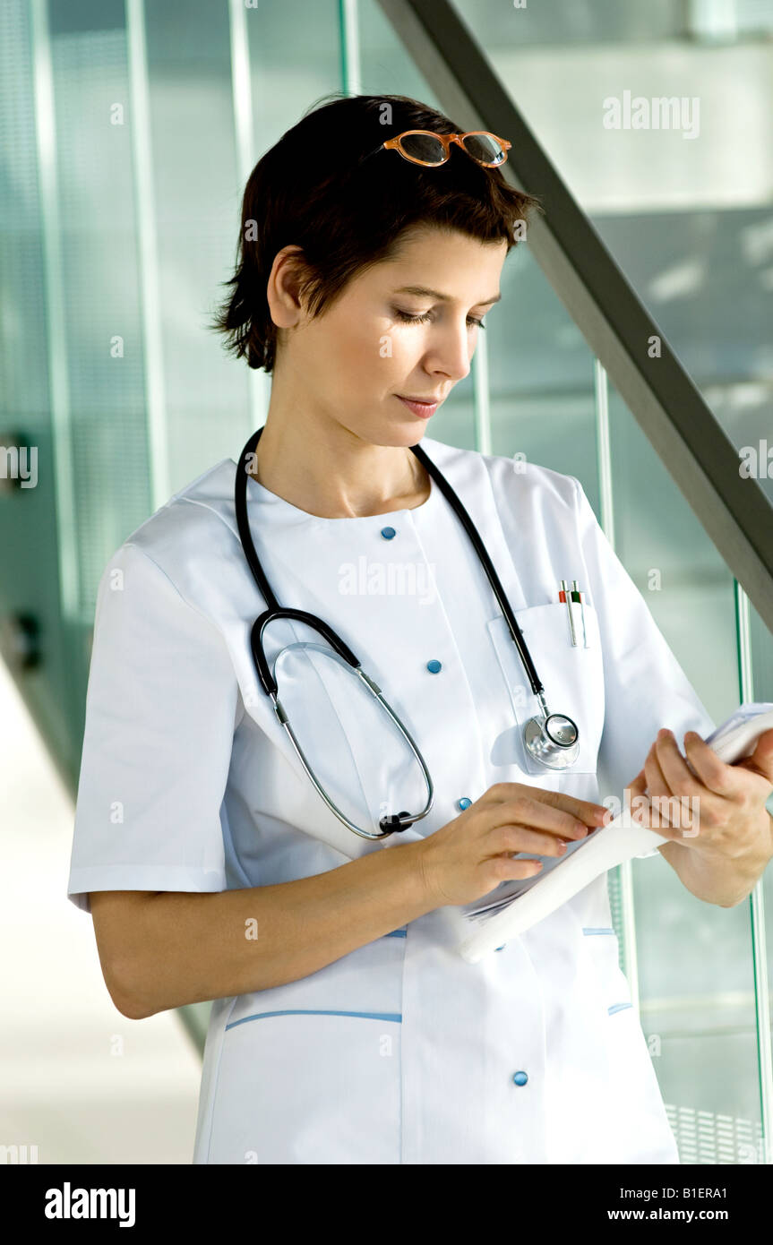 Female doctor reading medical records Stock Photo - Alamy