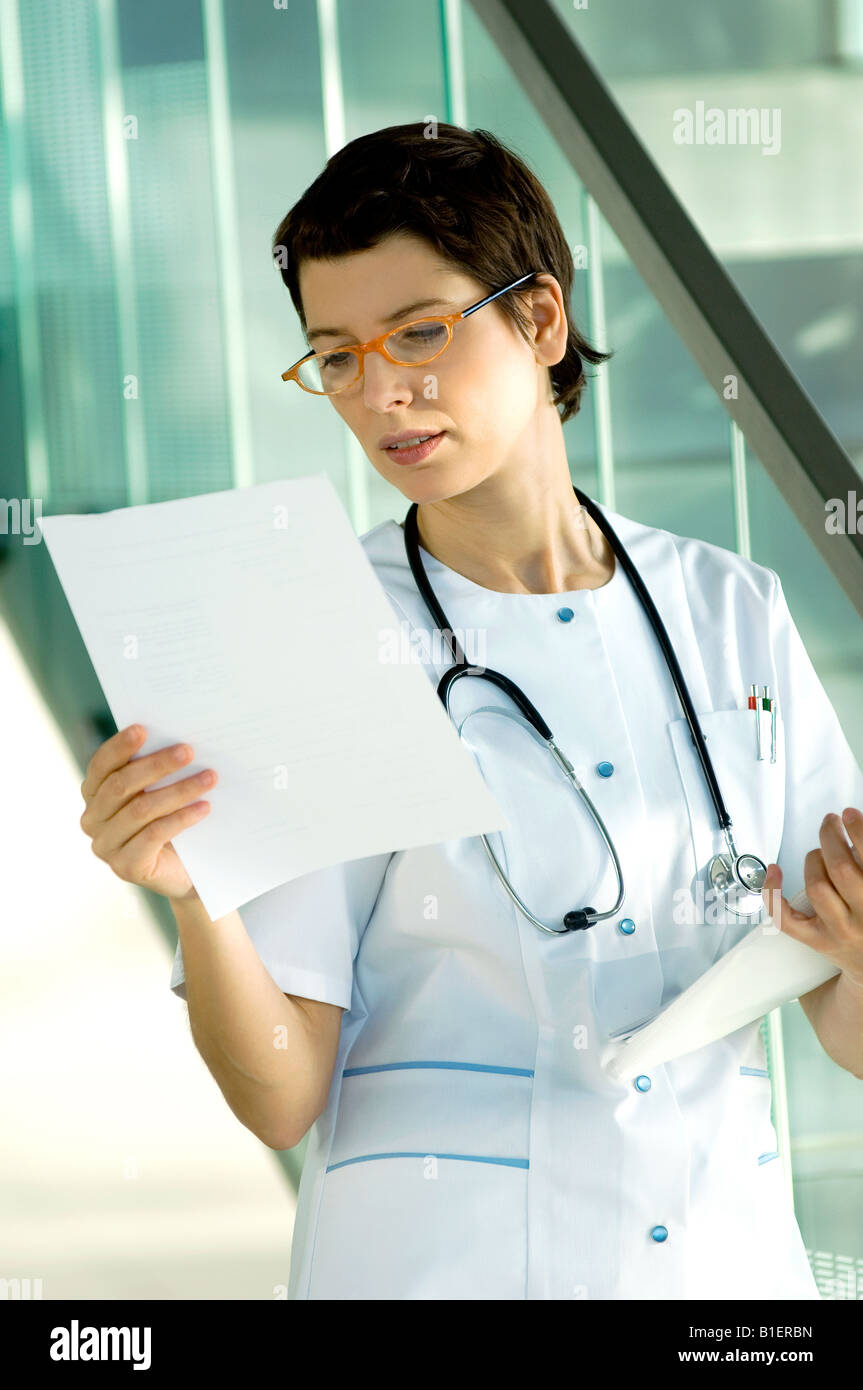 Female doctor reading medical records Stock Photo - Alamy