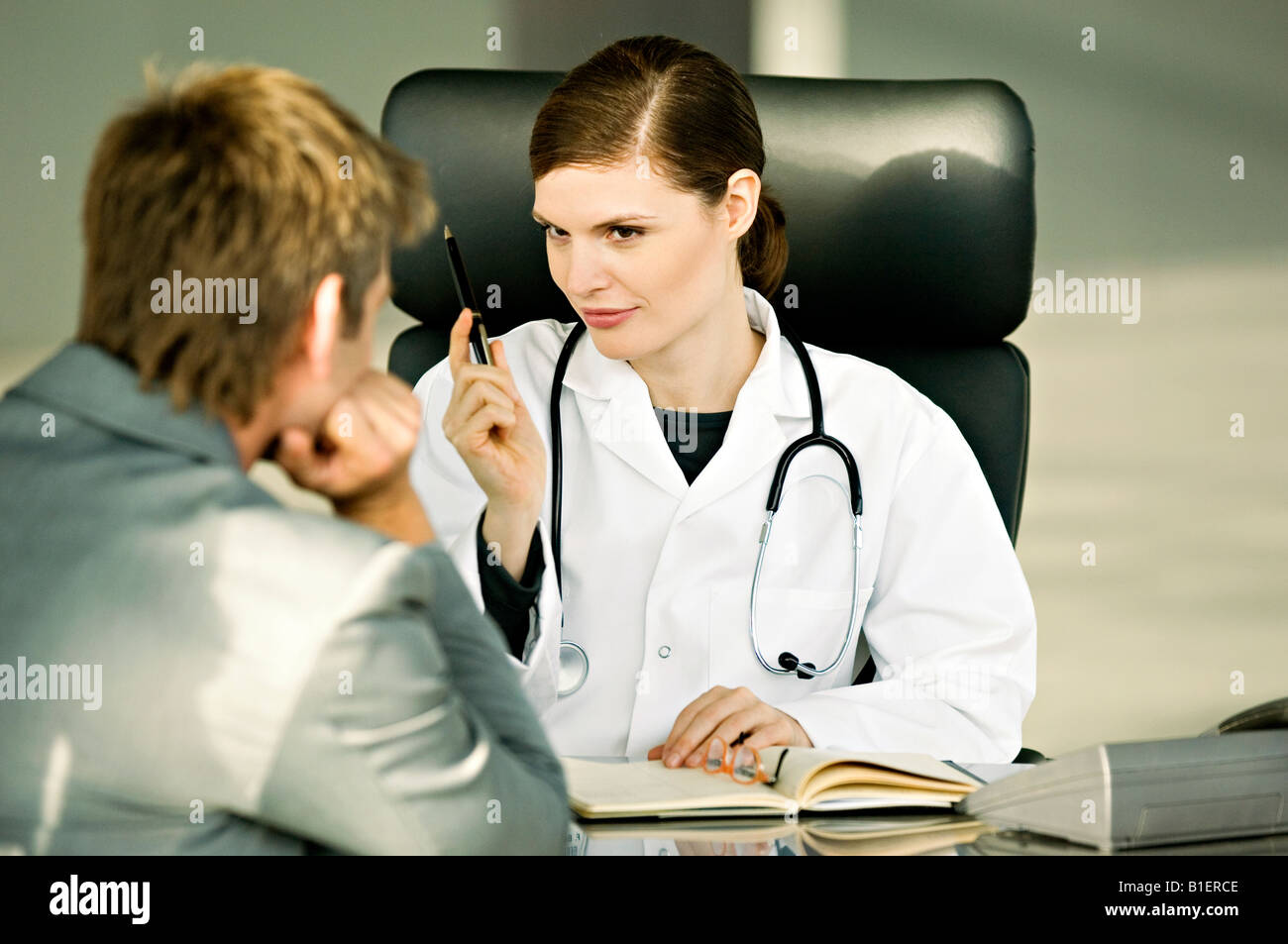 Female doctor explaining to a patient Stock Photo - Alamy