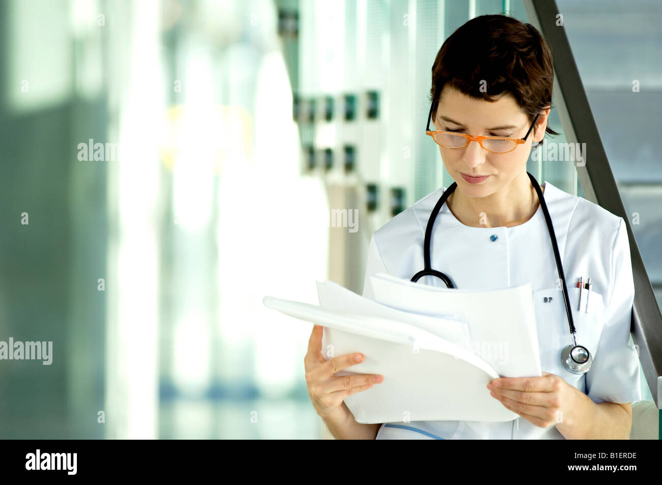 Female doctor reading medical records Stock Photo - Alamy