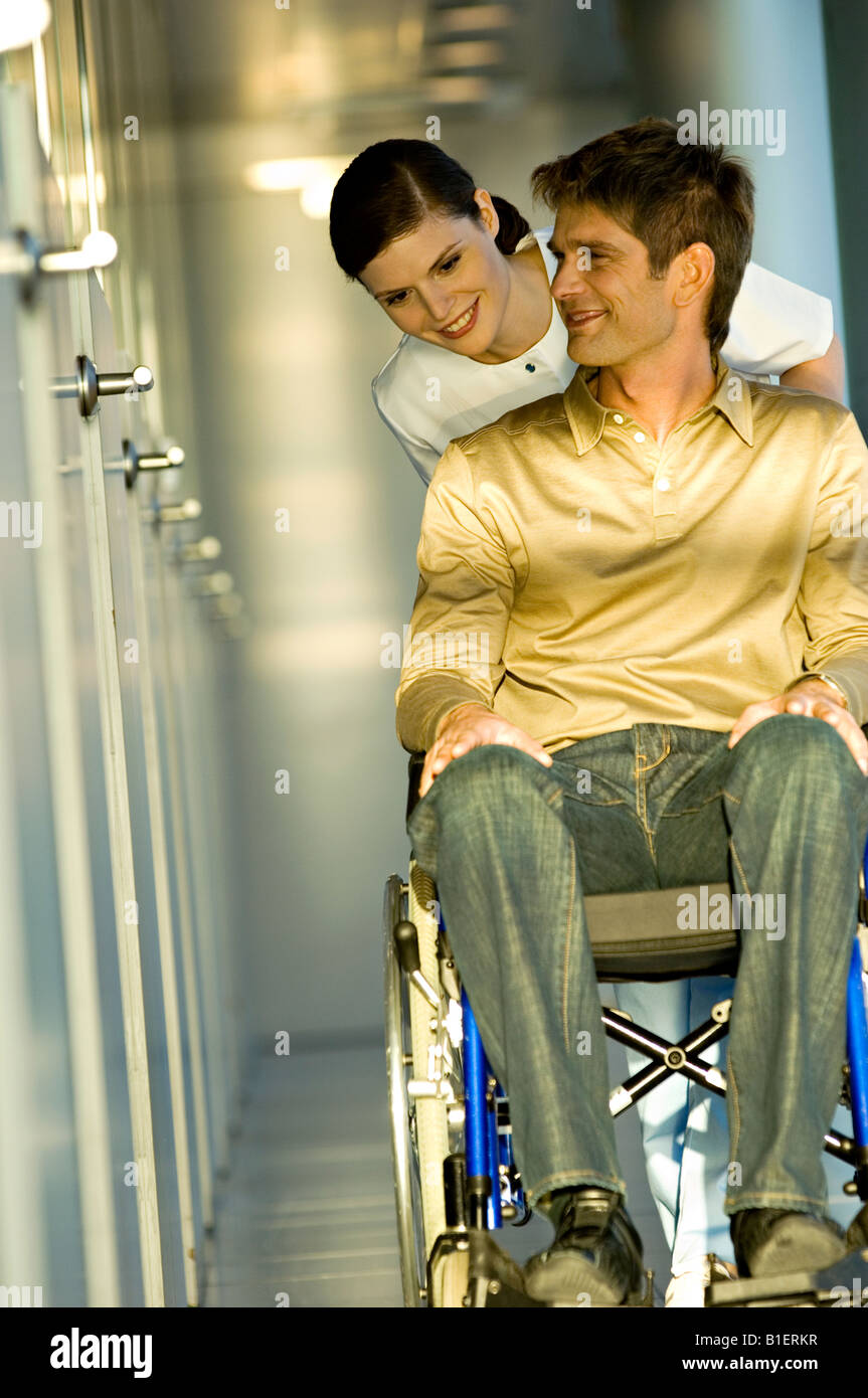 Female doctor pushing a male patient sitting in a wheelchair Stock ...