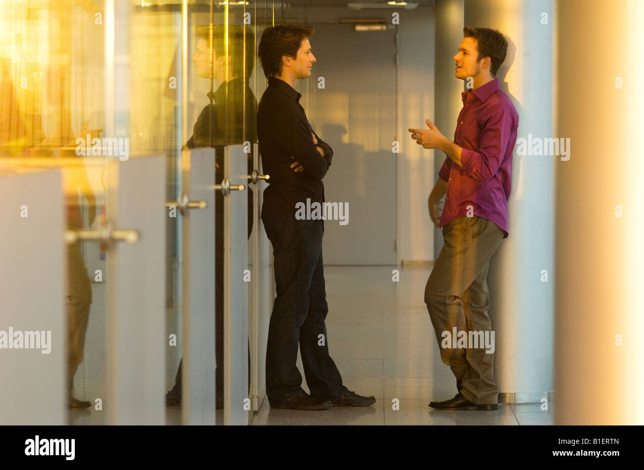 Side profile of two businessmen talking with each other Stock Photo - Alamy