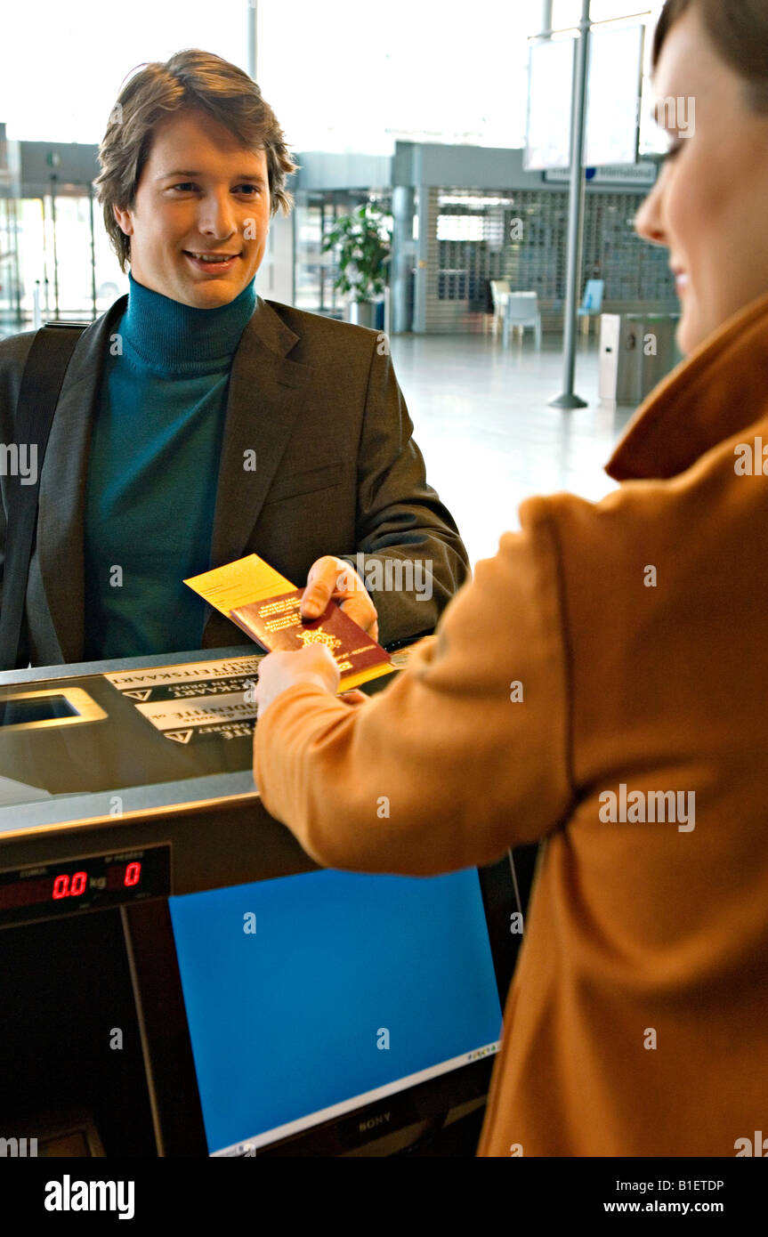 Businessman with a female check-in attendant at an airport check-in ...
