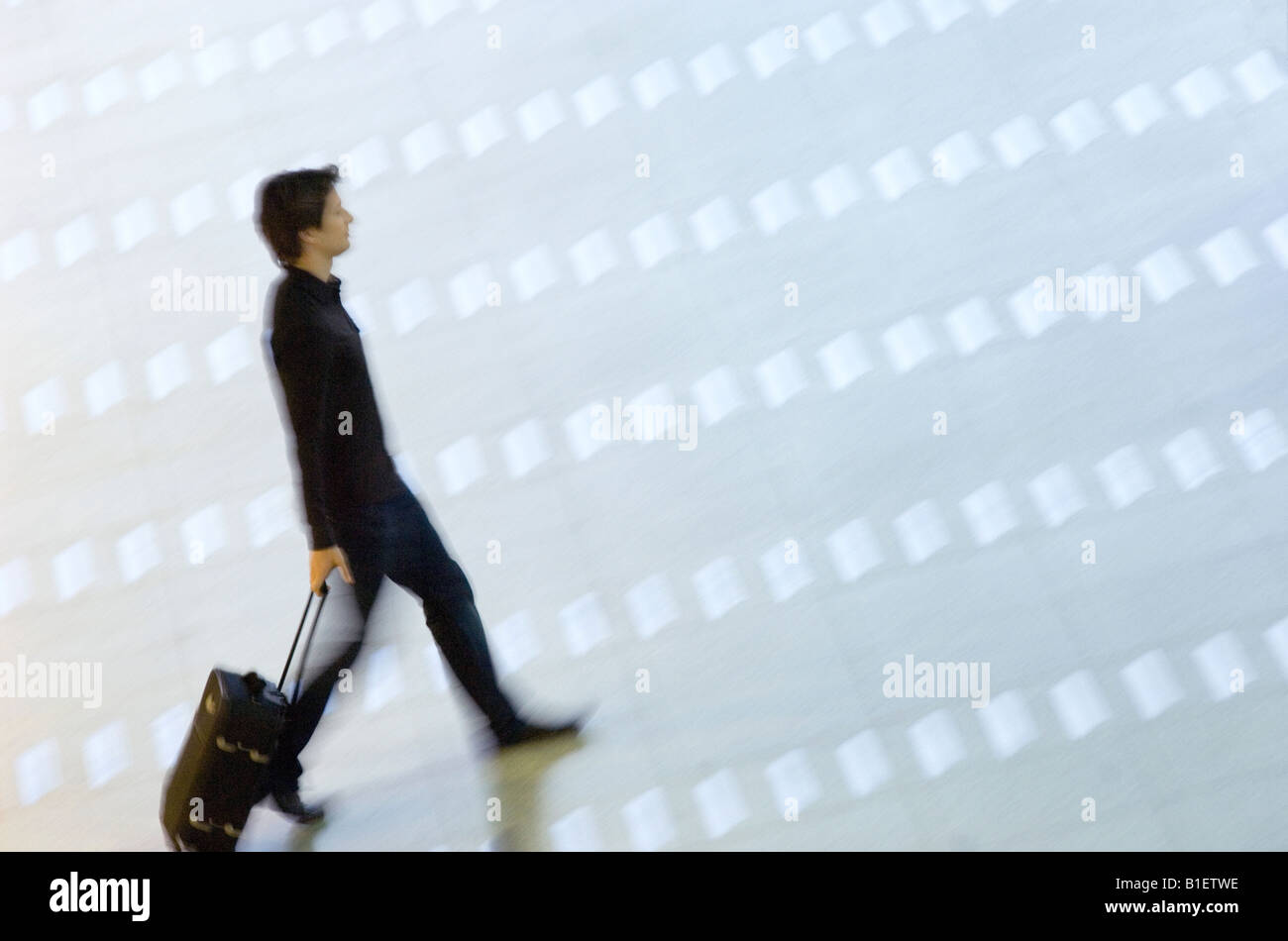 High angle view of a man pulling his luggage at an airport lobby Stock ...