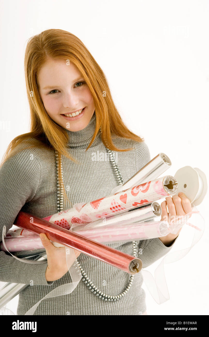 Portrait of a young woman holding rolls of wrapping papers and smiling ...