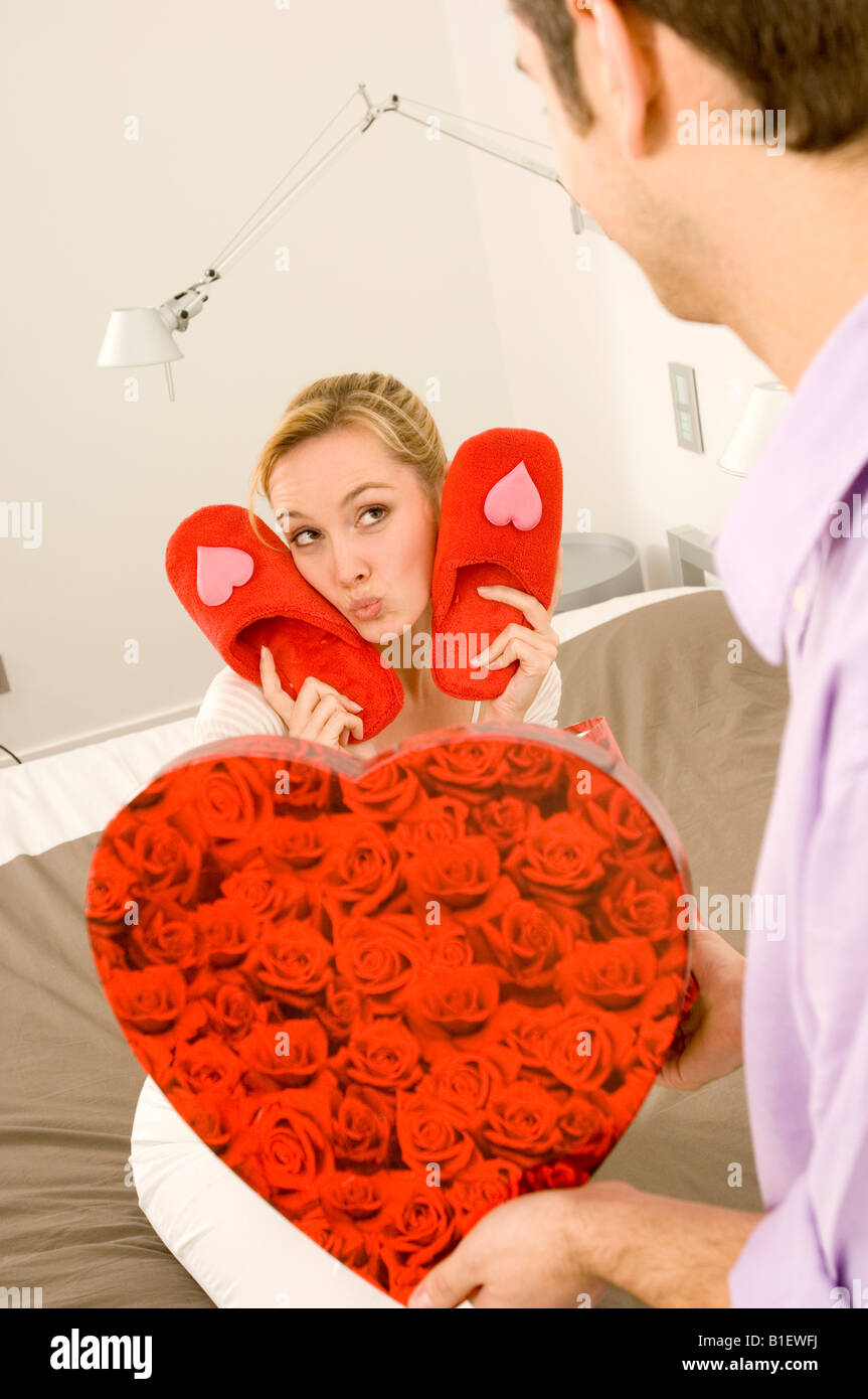 Young man giving a pair of slippers to a young woman Stock Photo - Alamy