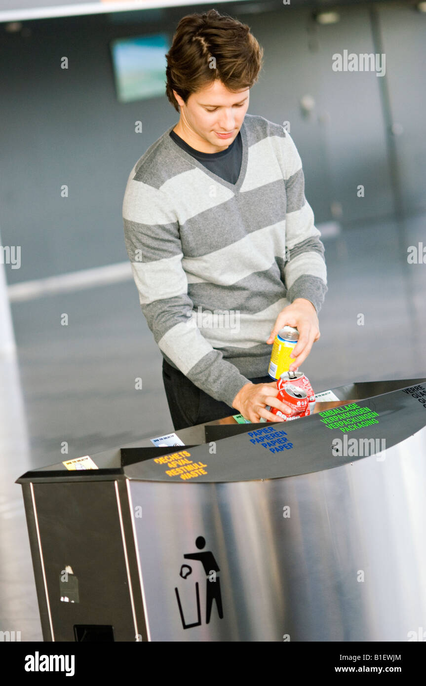 Mid adult man putting empty cans into a garbage bin Stock Photo - Alamy