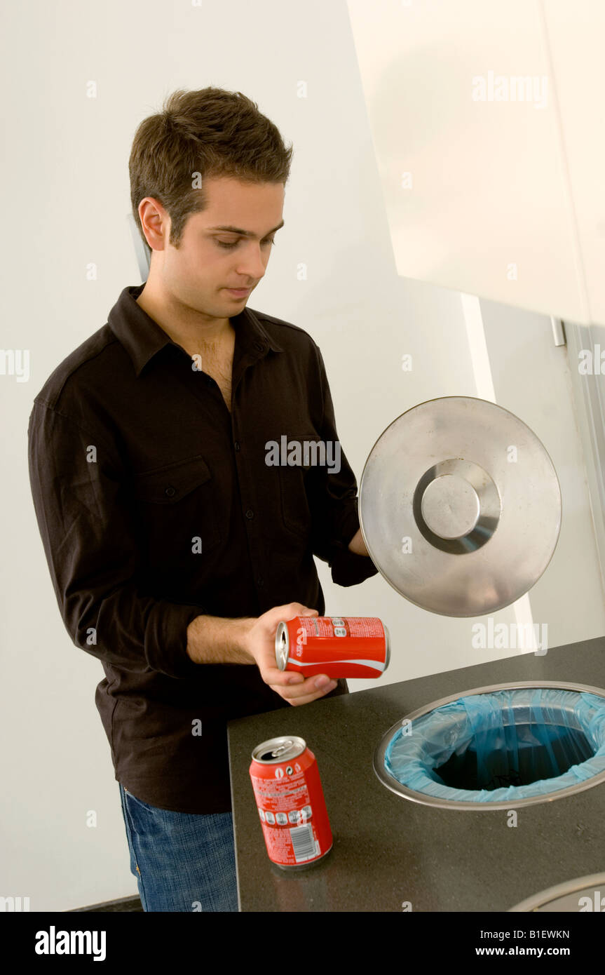 Young man putting a drink can in a garbage bin Stock Photo - Alamy
