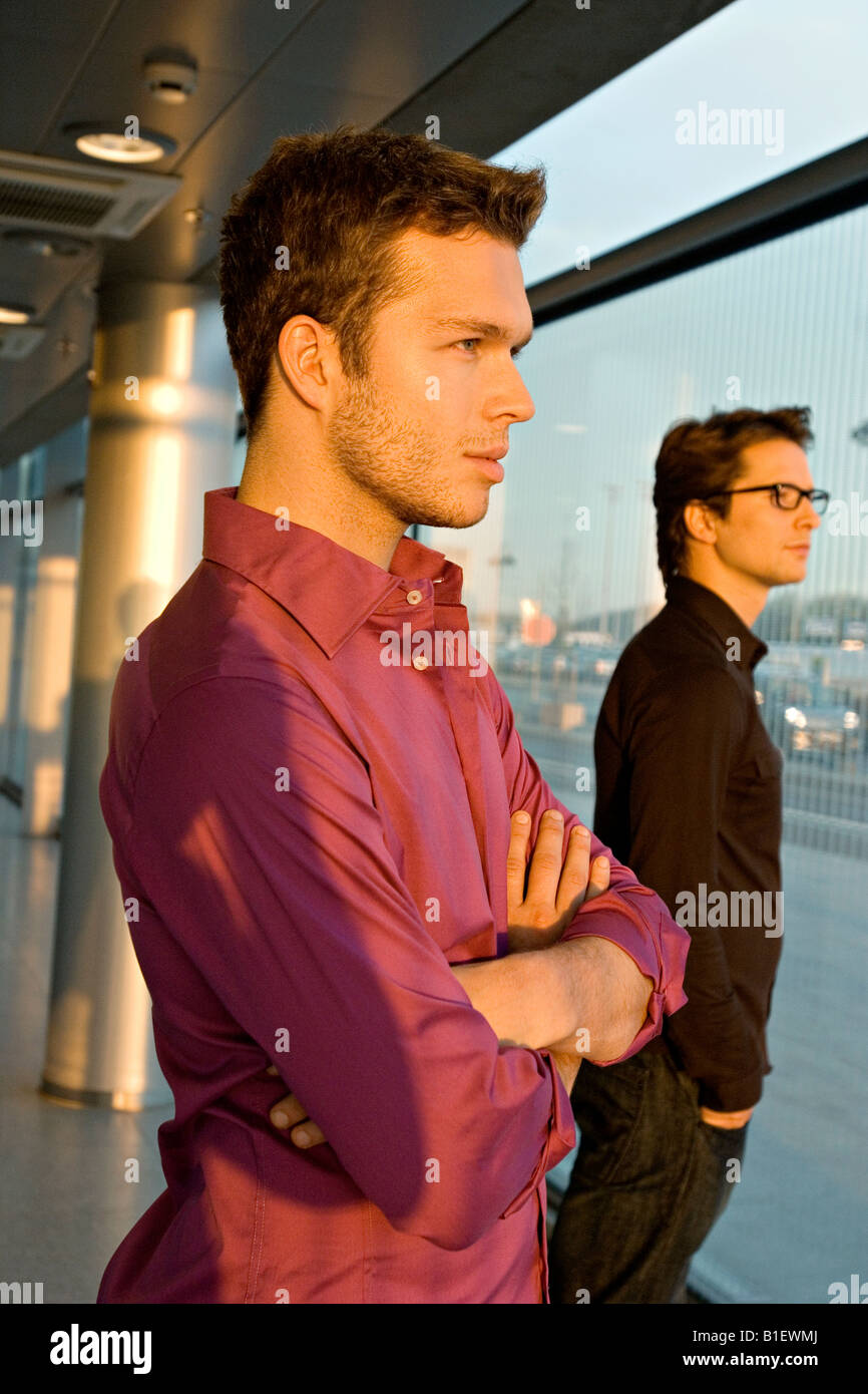 Side profile of two businessmen standing together Stock Photo - Alamy