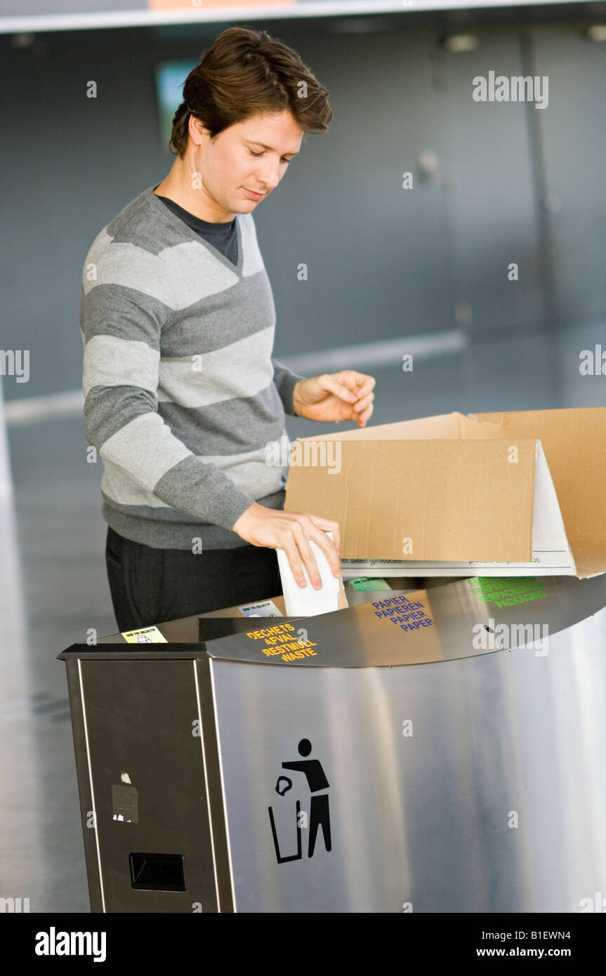 Mid adult man putting garbage into a garbage bin Stock Photo - Alamy