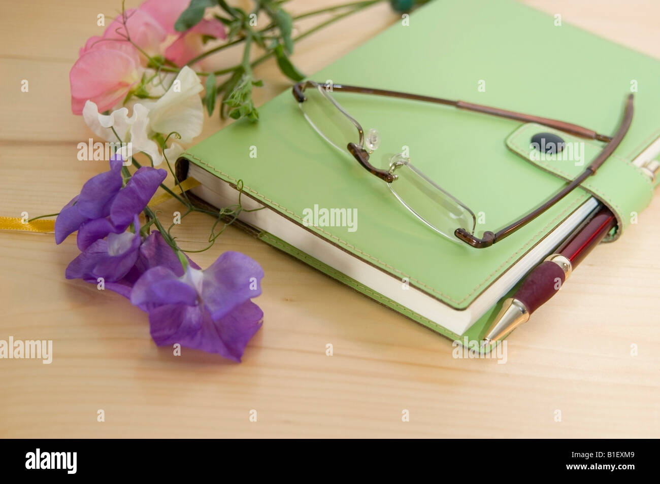 Still life of journal and flowers sitting on a table Stock Photo - Alamy