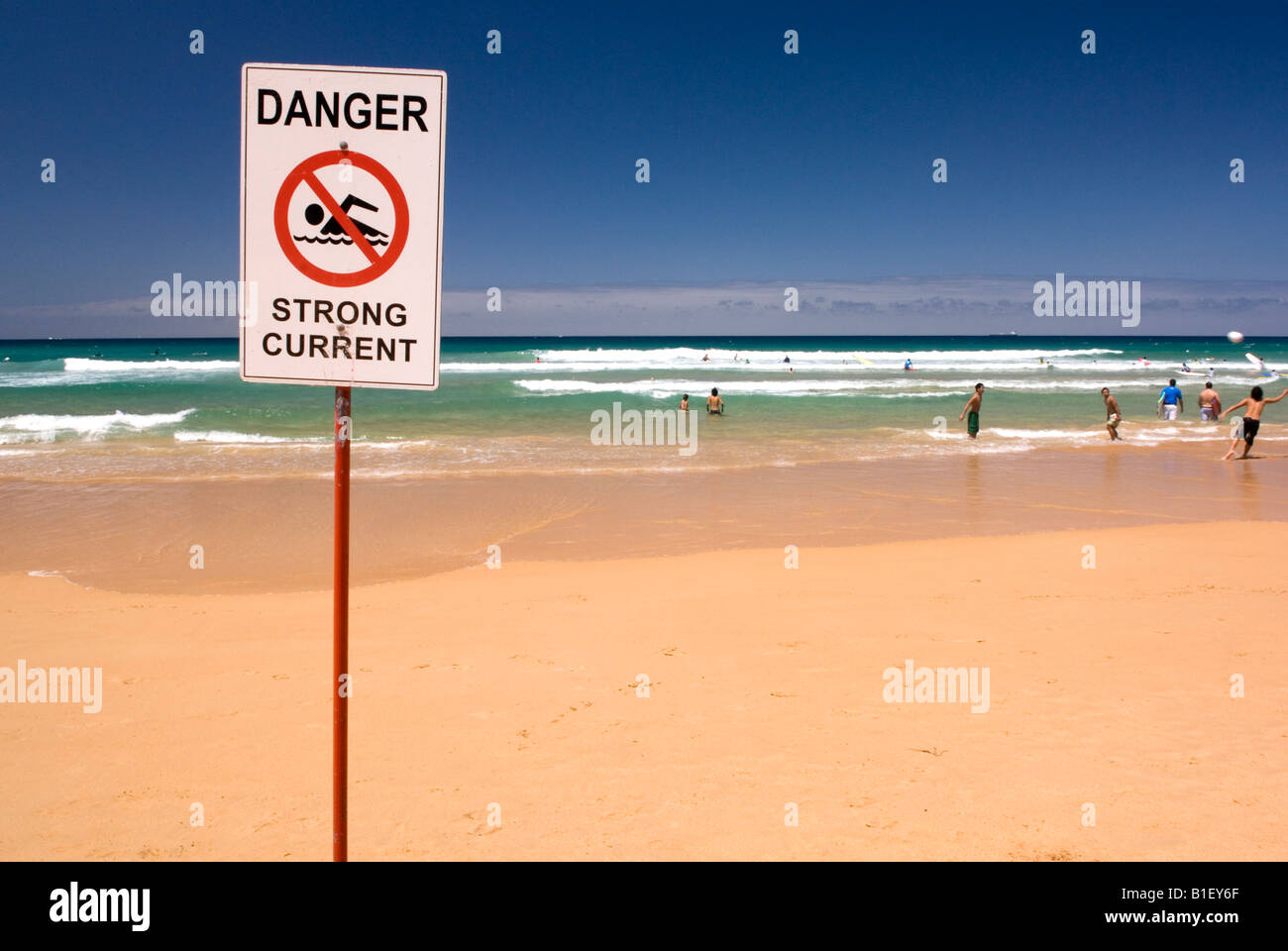 A warning sign alerts surfers and swimmers to the dangerous currents at ...