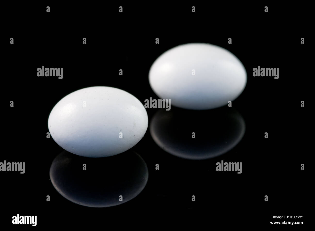 Two white tablets on a black background Stock Photo - Alamy