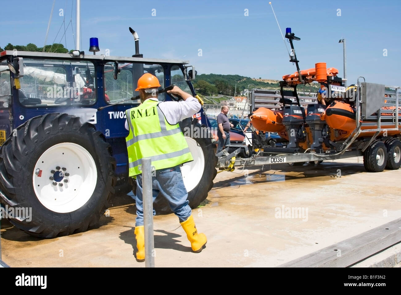 Crew washing the inshore lifeboat tractor Stock Photo - Alamy