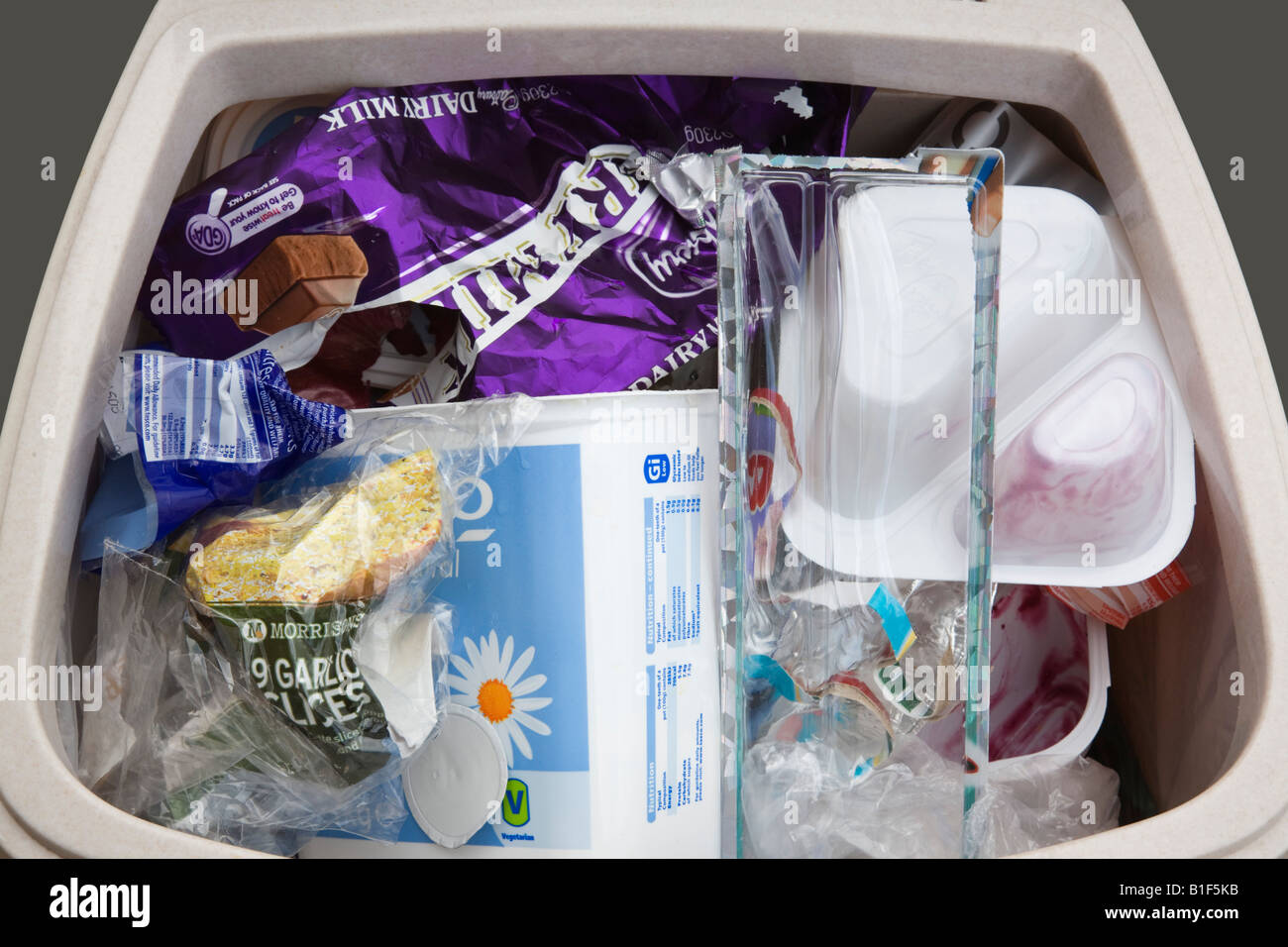 Single-use plastic household rubbish thrown out in waste bin from above ...