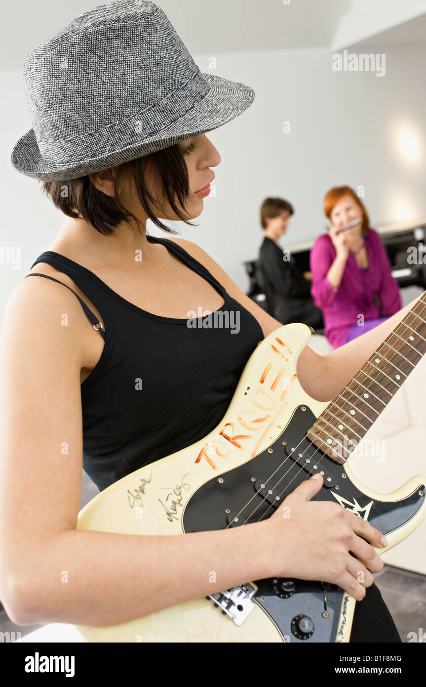Side profile of a young woman playing a guitar Stock Photo - Alamy