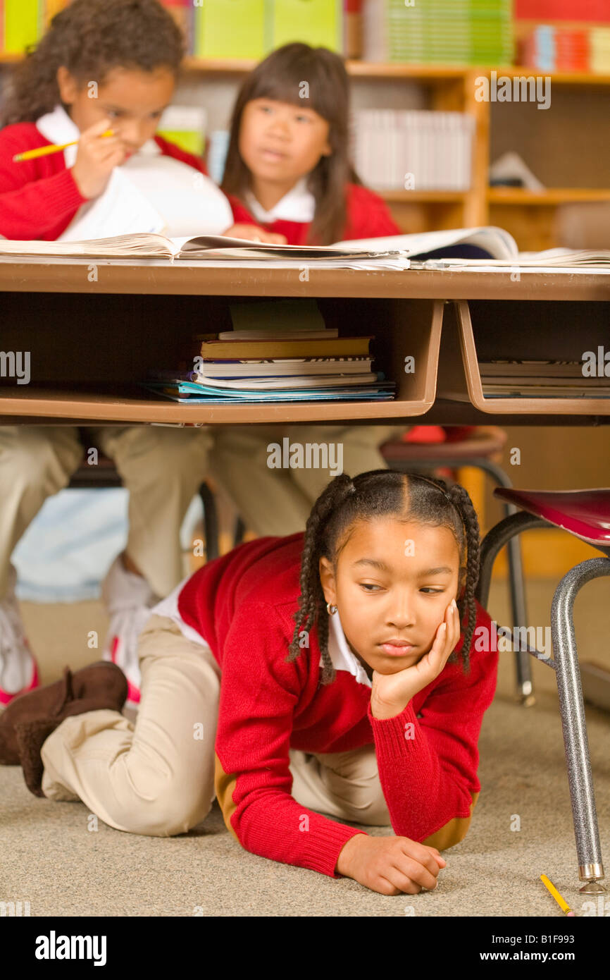 African girl sitting under school desk Stock Photo - Alamy
