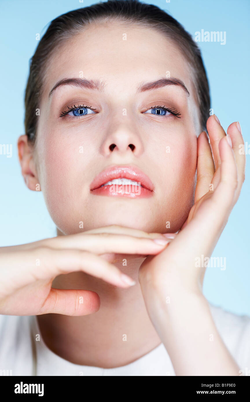 Young woman with hand on cheek Stock Photo - Alamy