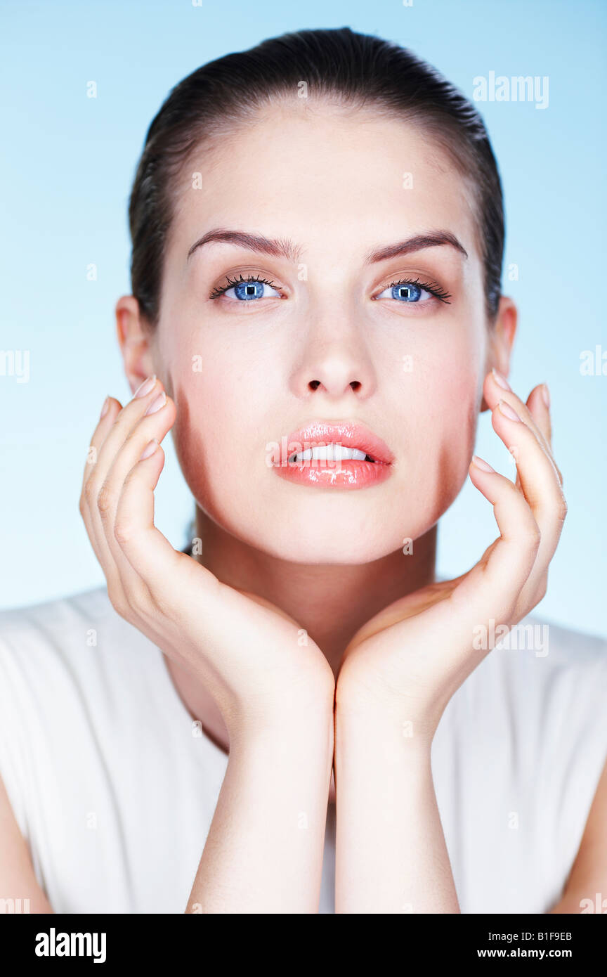 Young woman with hands on cheeks Stock Photo - Alamy