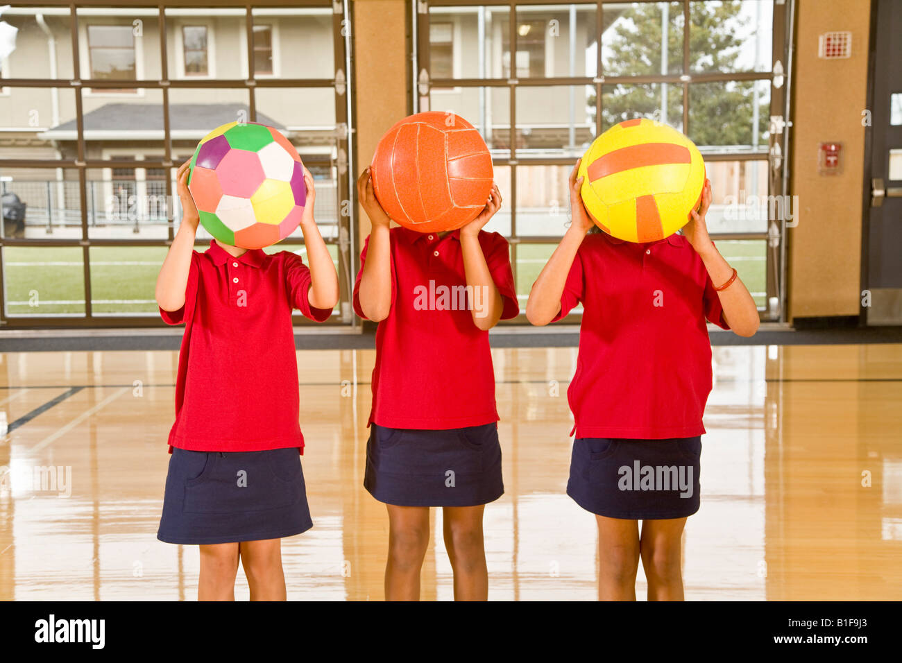 Multi-ethnic girls holding sports balls Stock Photo - Alamy