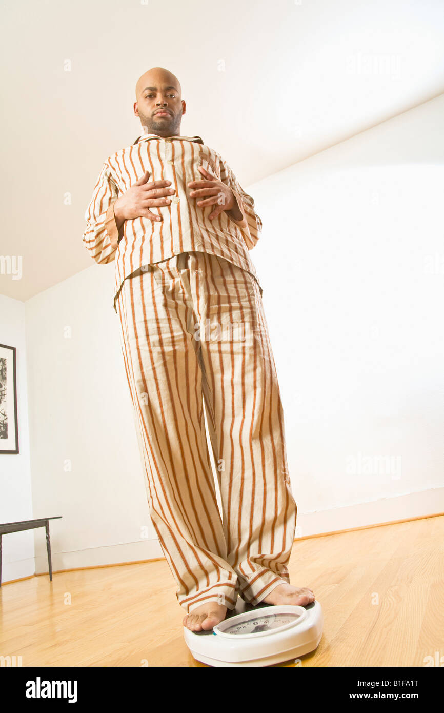 African man standing on scale Stock Photo - Alamy