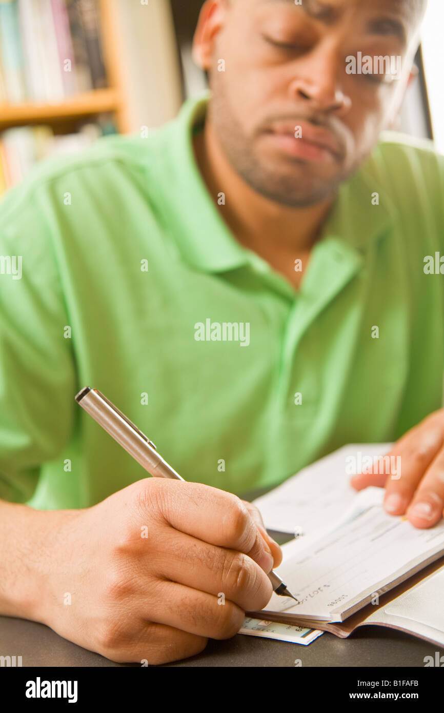 African man writing check Stock Photo - Alamy