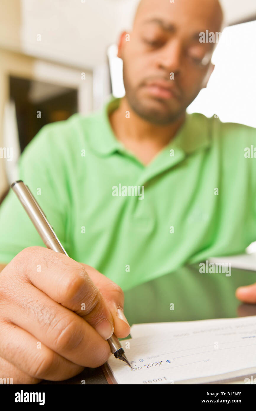 African man writing check Stock Photo - Alamy