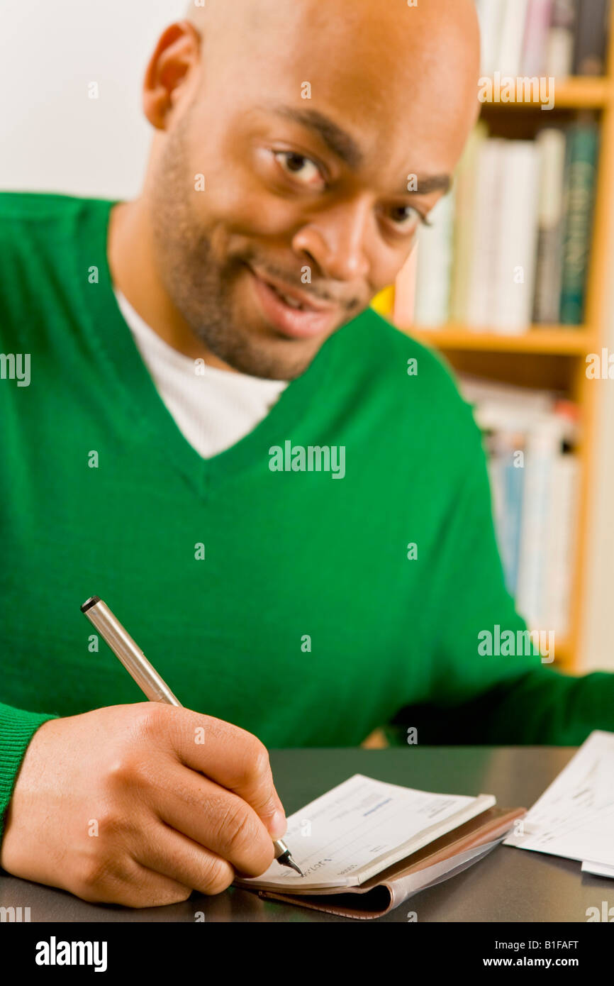 African man writing check Stock Photo - Alamy