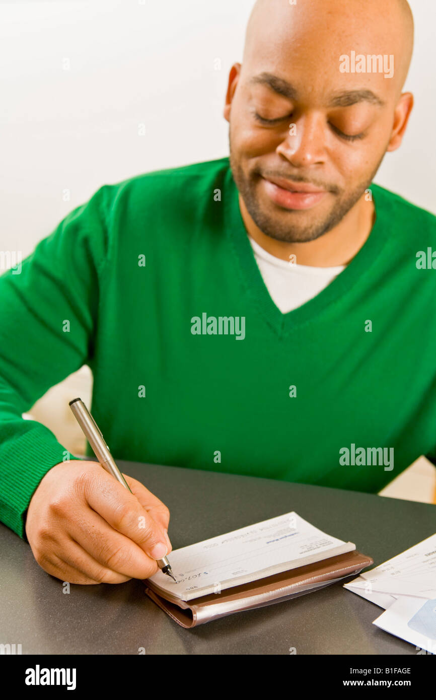 African man writing check Stock Photo - Alamy