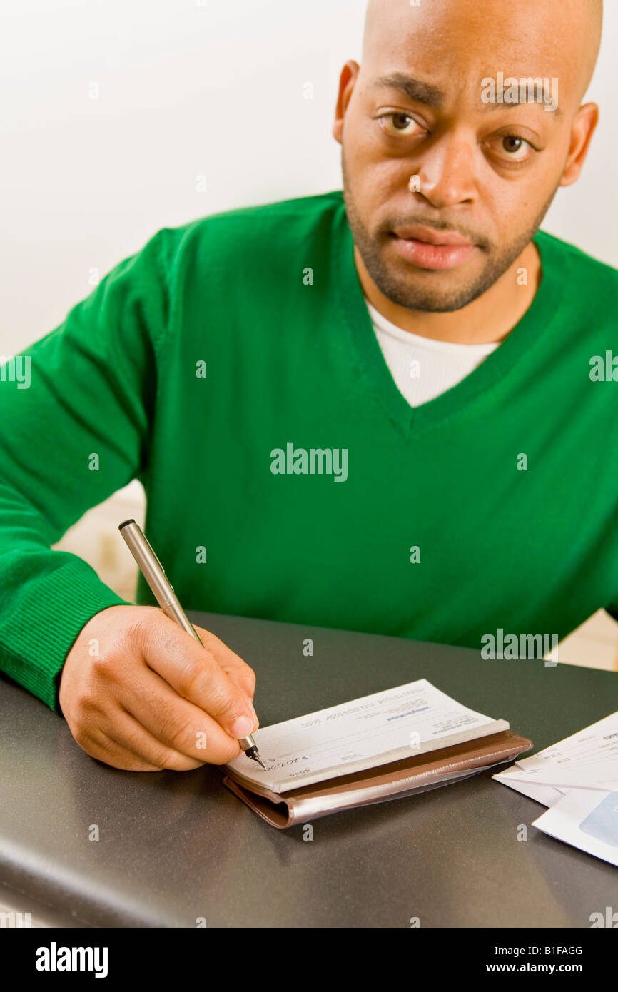 African man writing check Stock Photo - Alamy