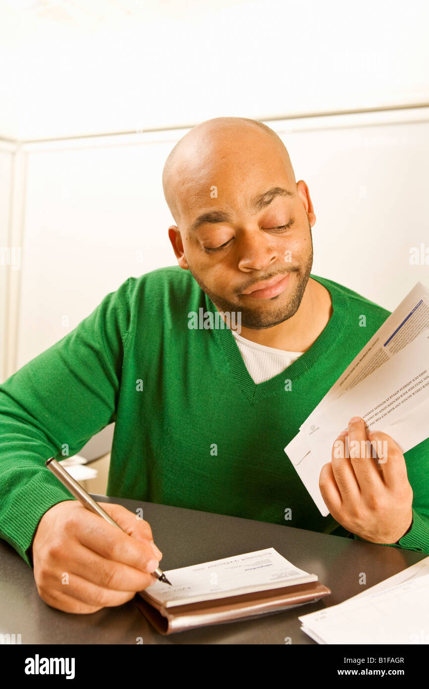 African man writing check Stock Photo - Alamy