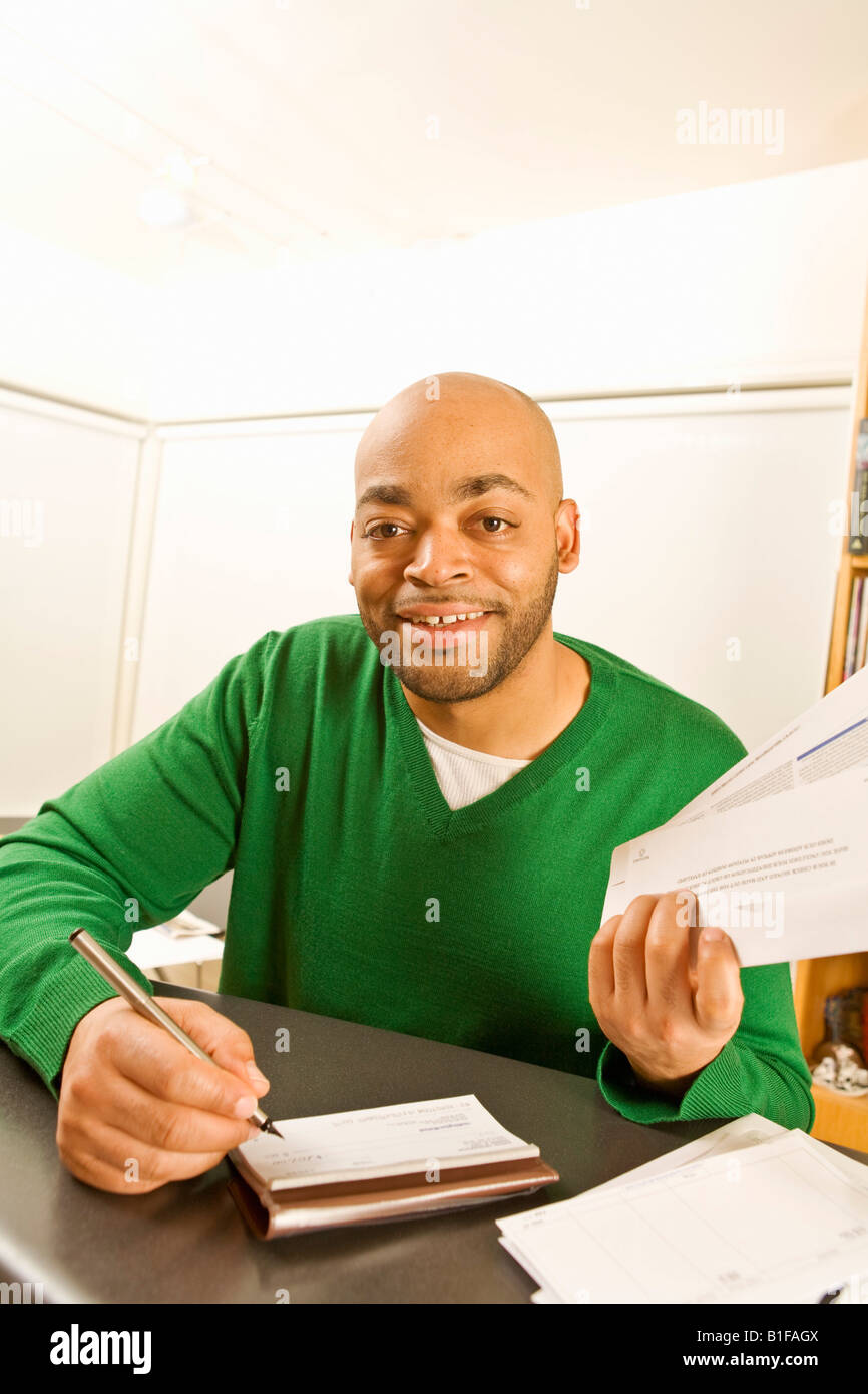 African man writing check Stock Photo - Alamy
