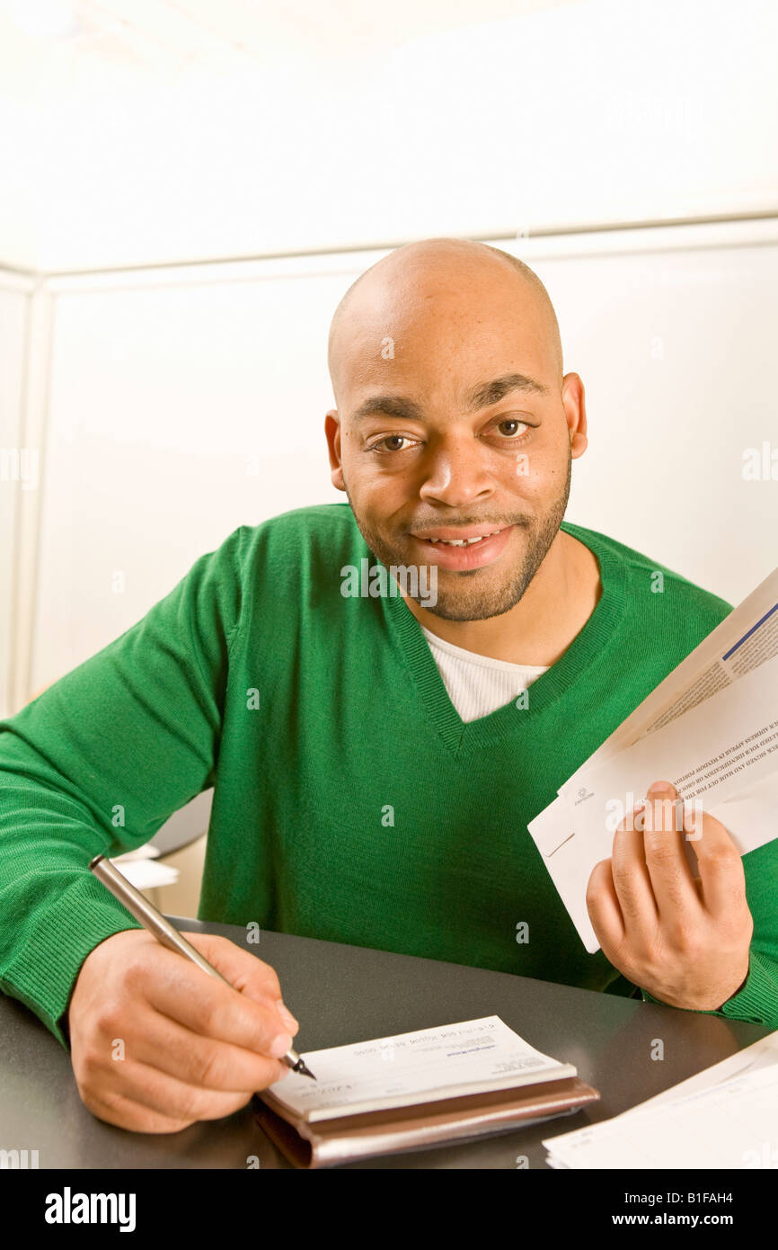 African man writing check Stock Photo - Alamy