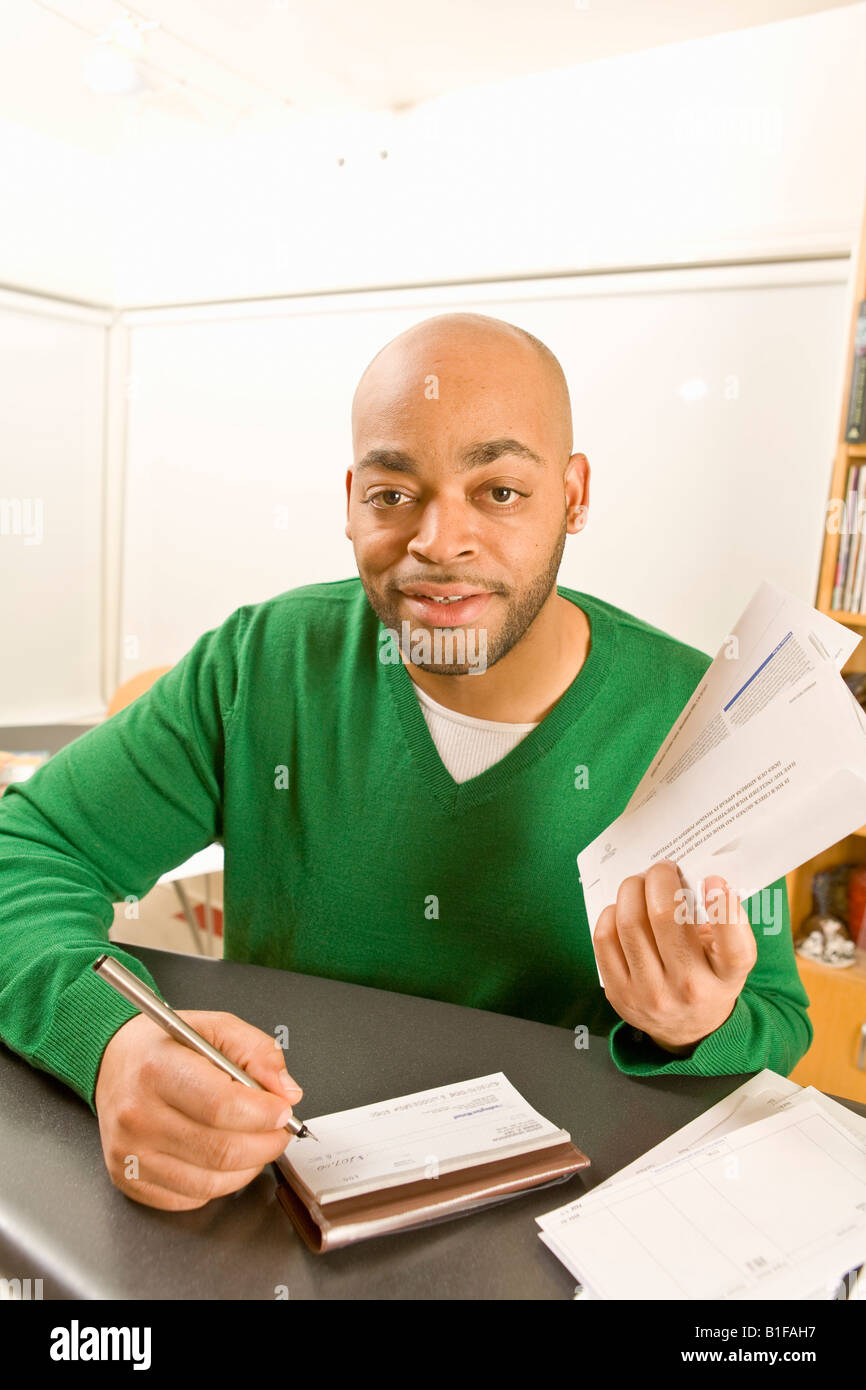 African man writing check Stock Photo - Alamy