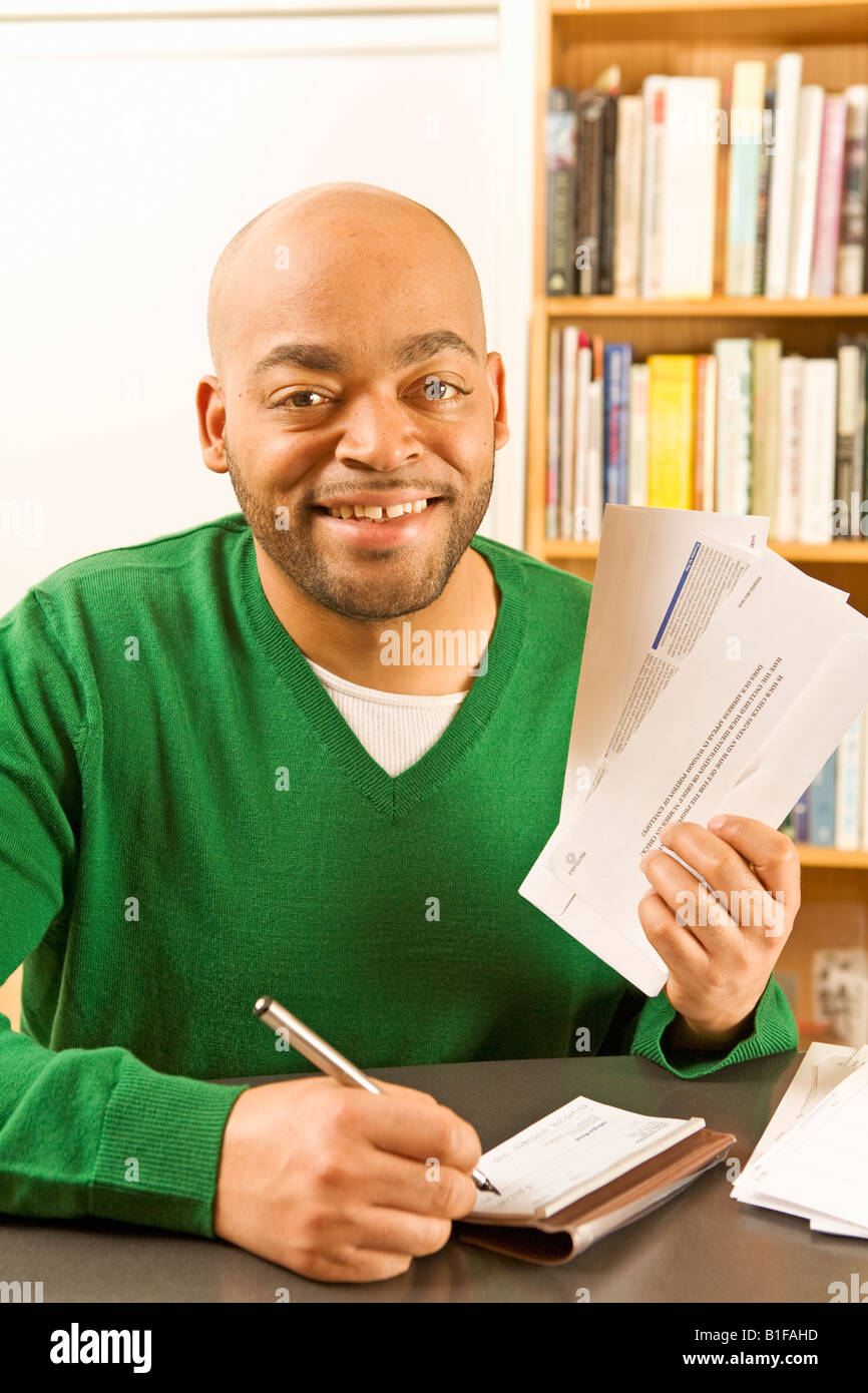 African man writing check Stock Photo - Alamy