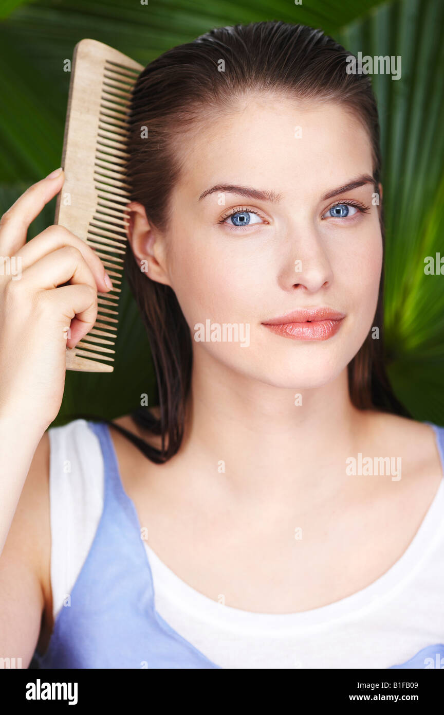 Young woman combing her hair Stock Photo - Alamy