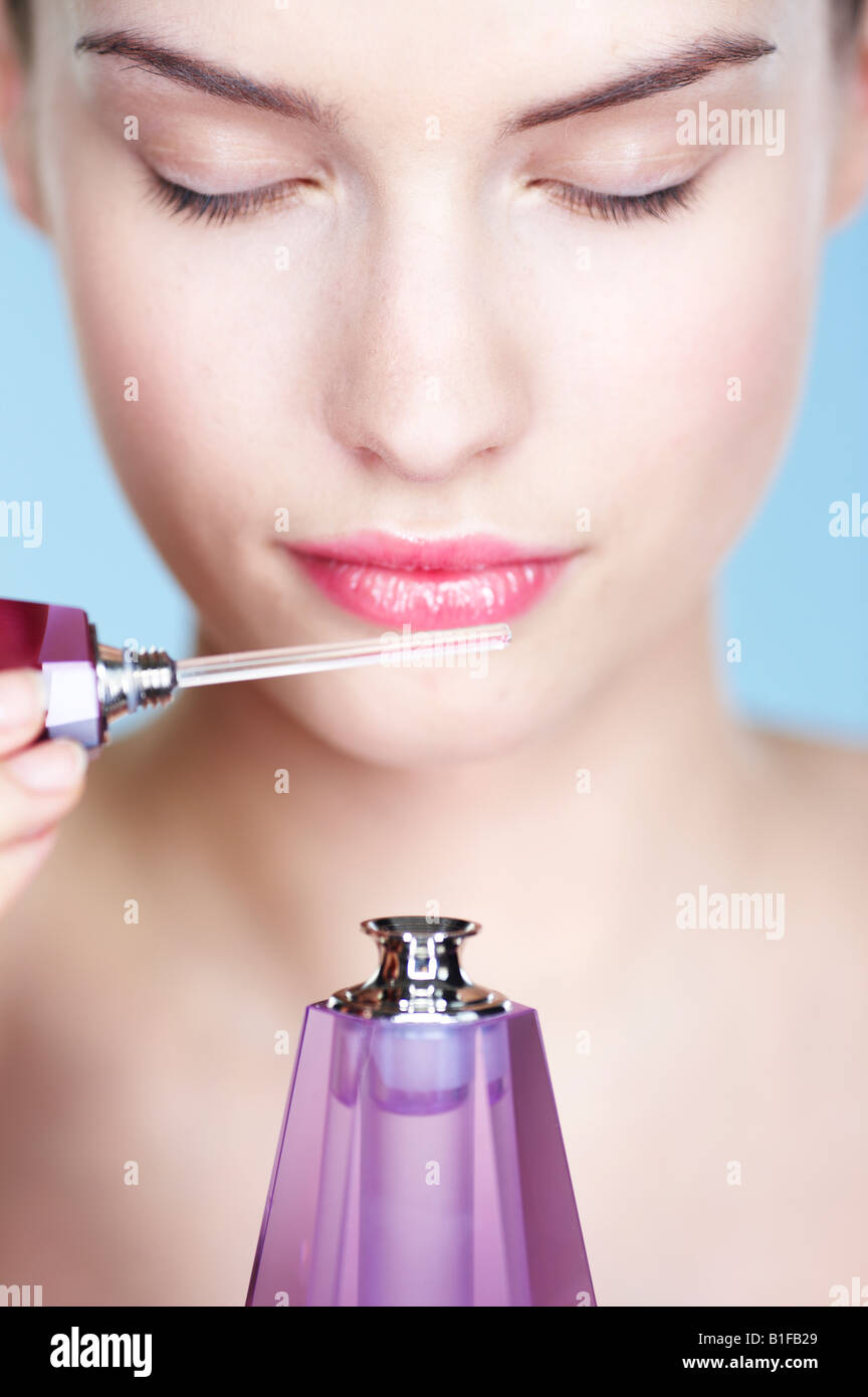 Young woman smelling perfume Stock Photo - Alamy