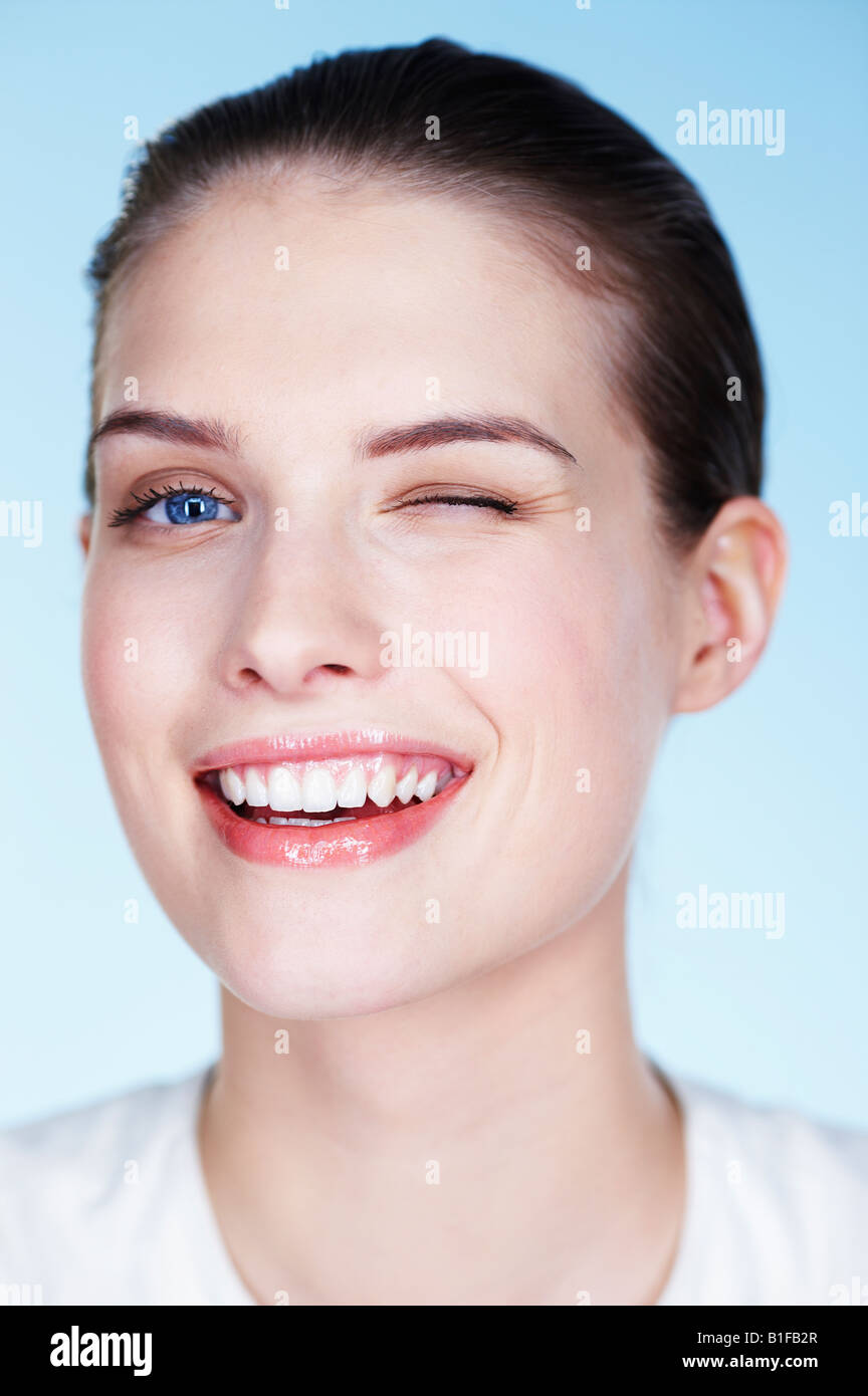 Portrait of young woman winking Stock Photo - Alamy