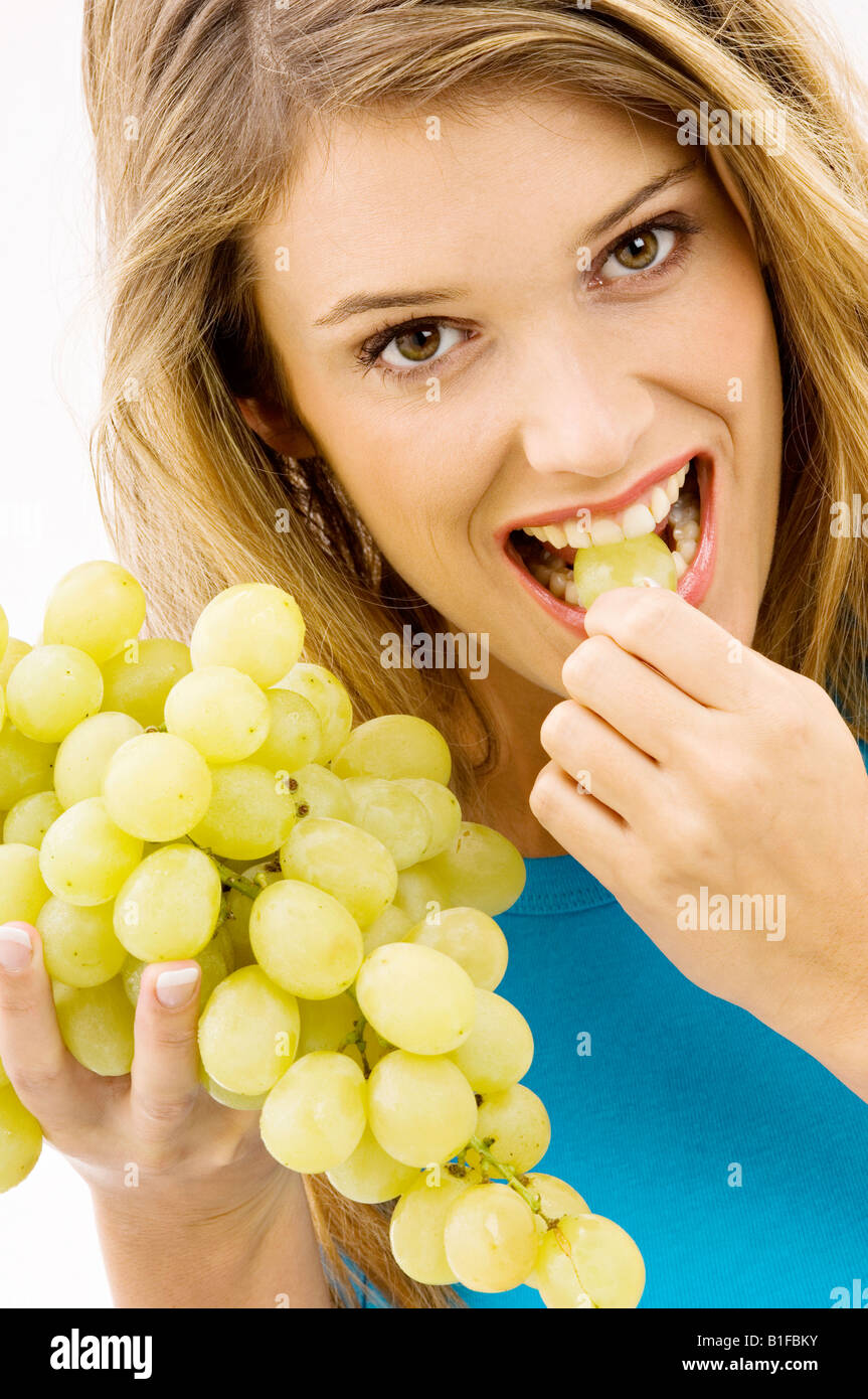 Portrait of a young woman eating grapes Stock Photo - Alamy