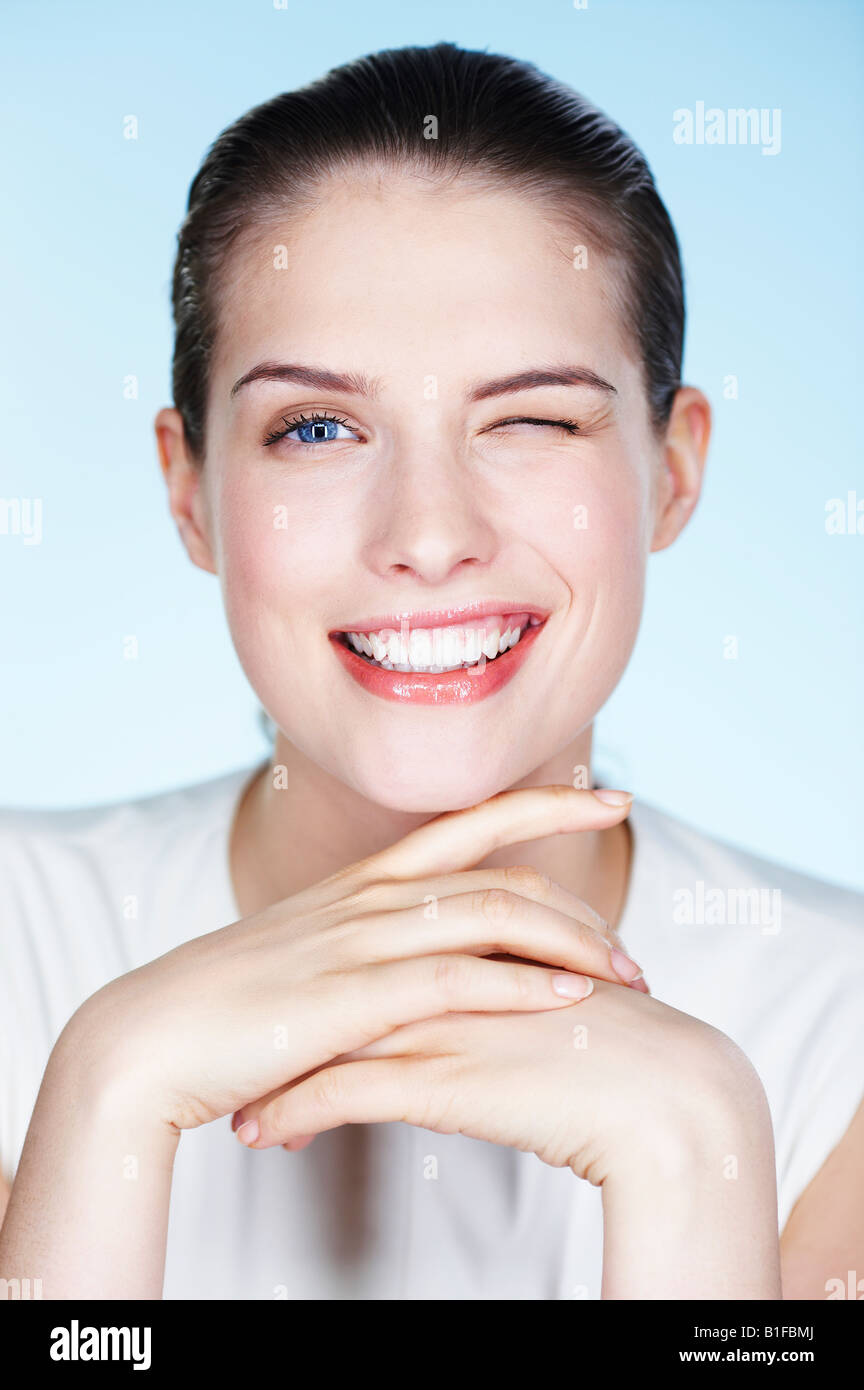 Portrait of young smiling woman winking Stock Photo - Alamy