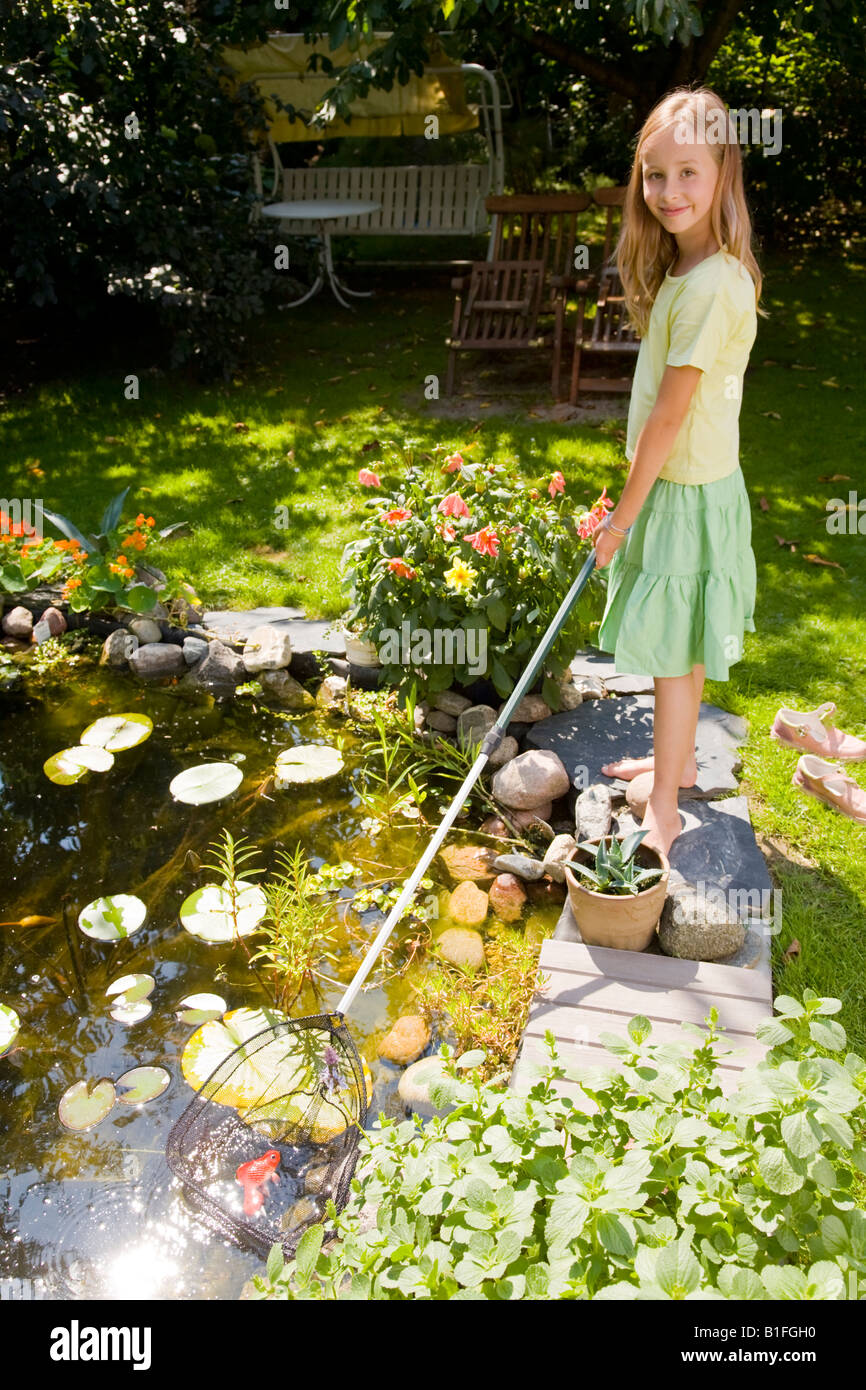young blonde girl on an garden pond Stock Photo - Alamy
