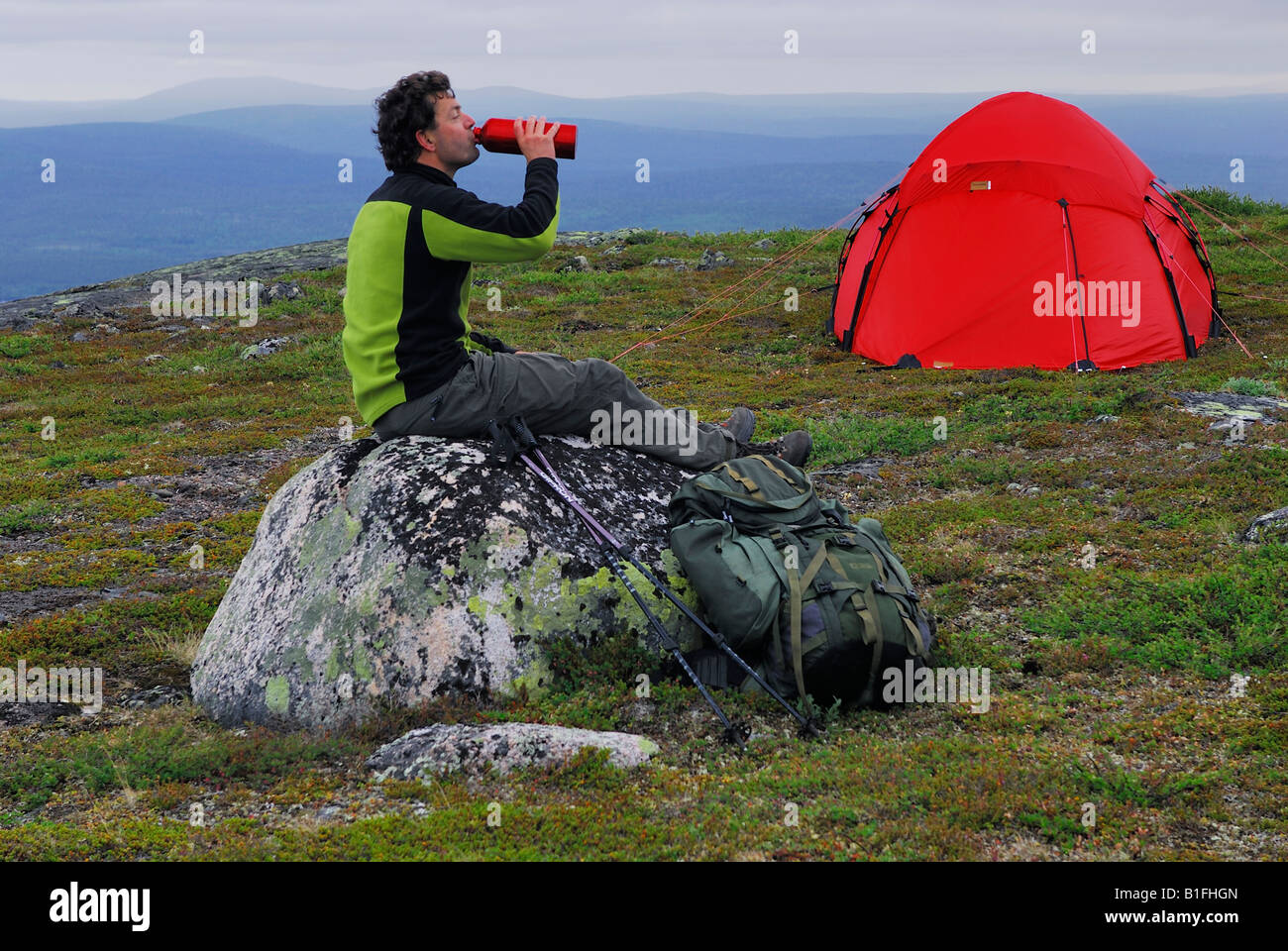 man sitting drinking on a rock atg the dundret mountain, gaellivare ...