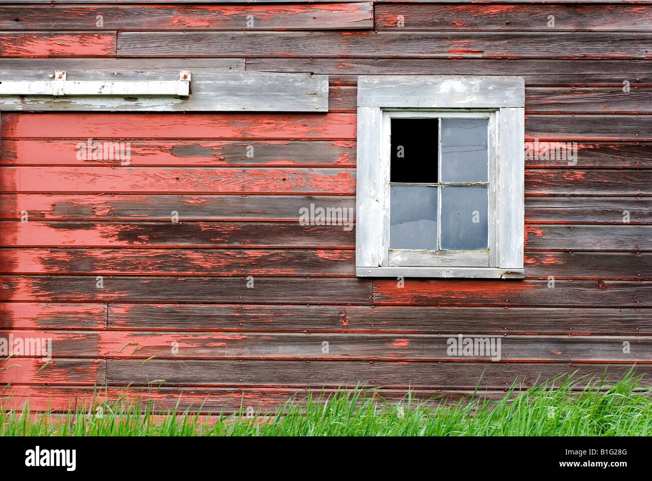 Broken window on side of red barn Stock Photo - Alamy
