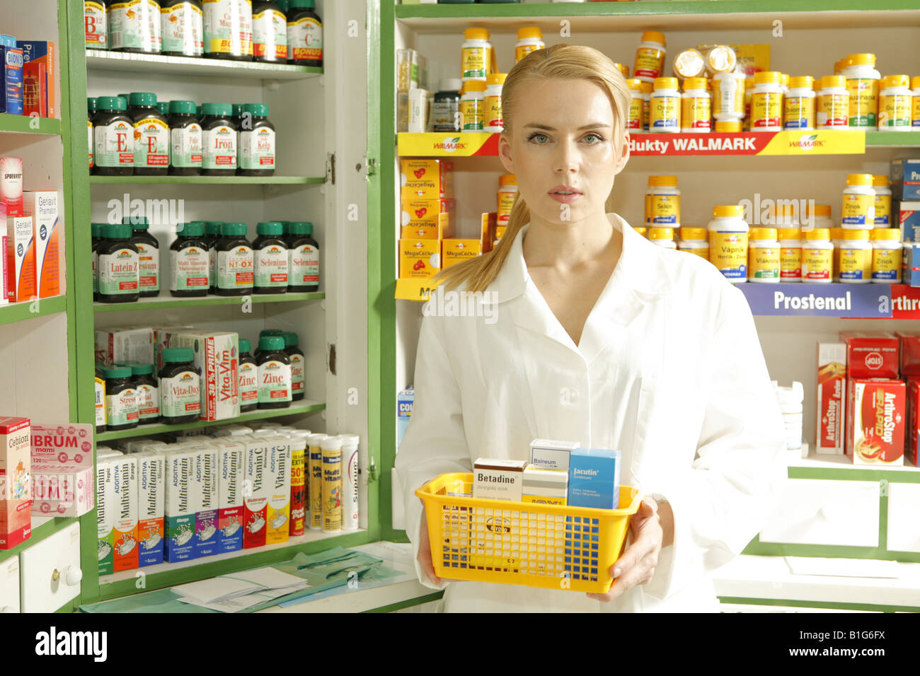 Young female pharmacist holding basket with drugs Stock Photo - Alamy